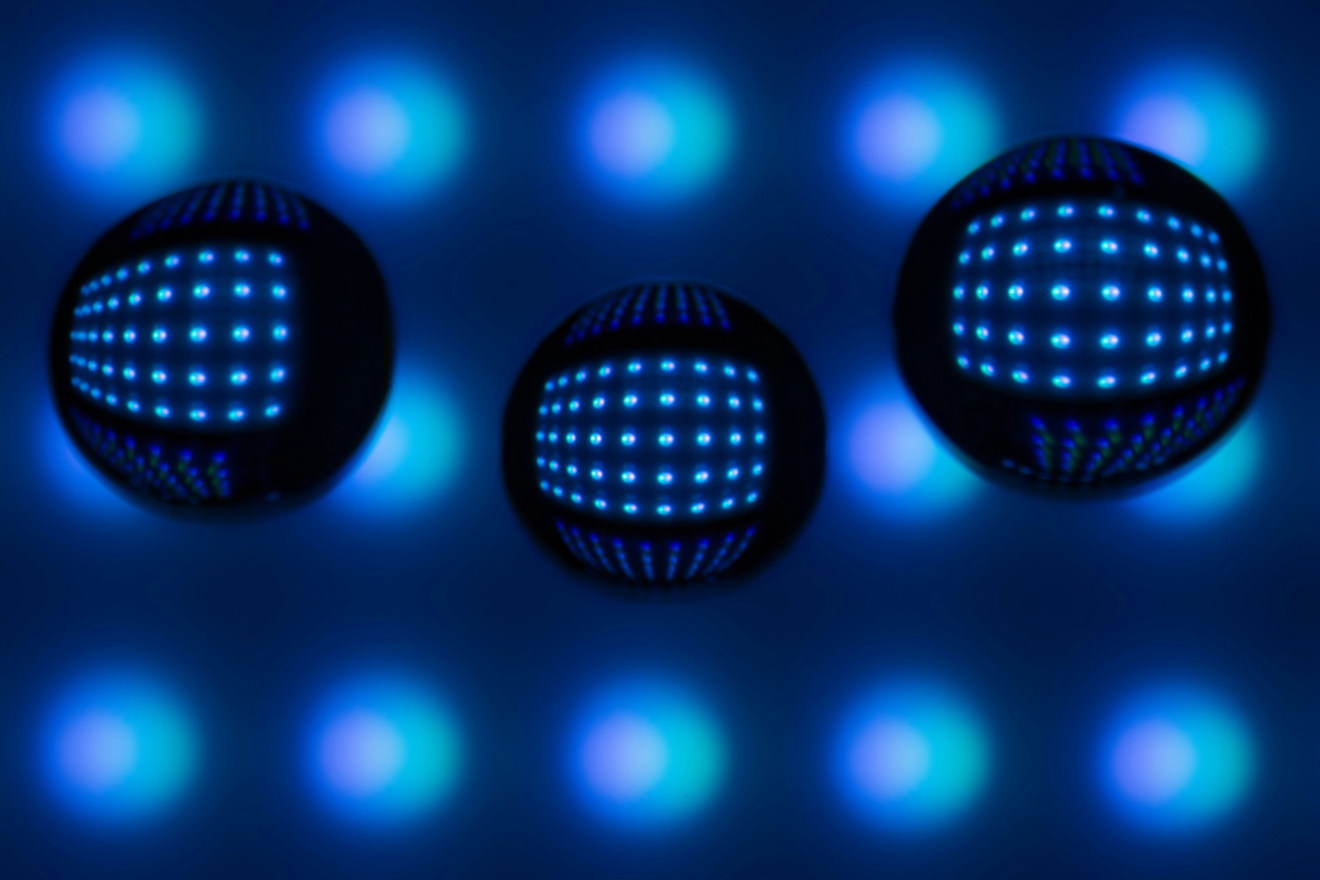 Orbital Blue: Three Dotted Spheres Hover over a Neon Grid