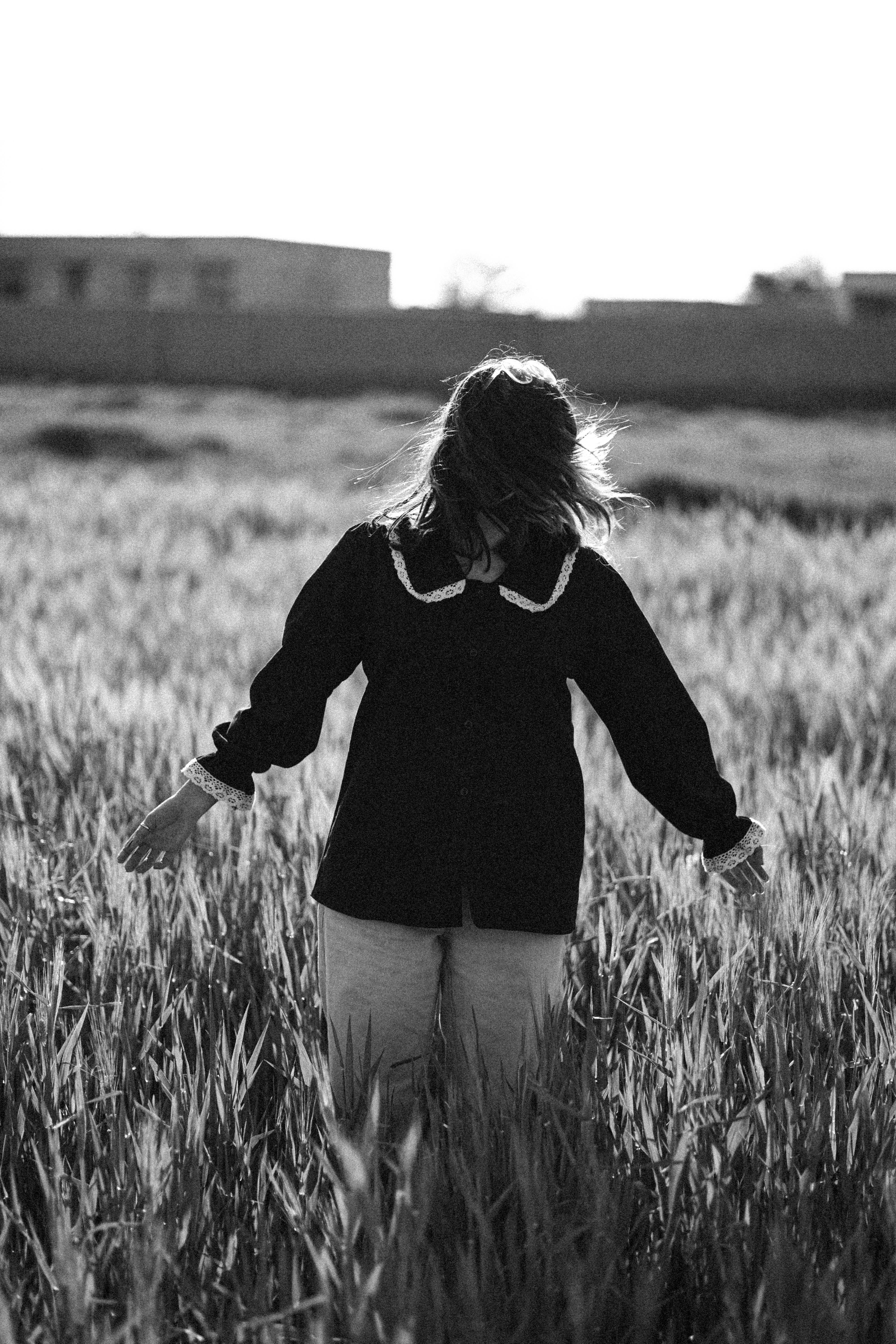 Field of Quiet: A Girl in a Dark Blouse Surrounded by Tall Grass