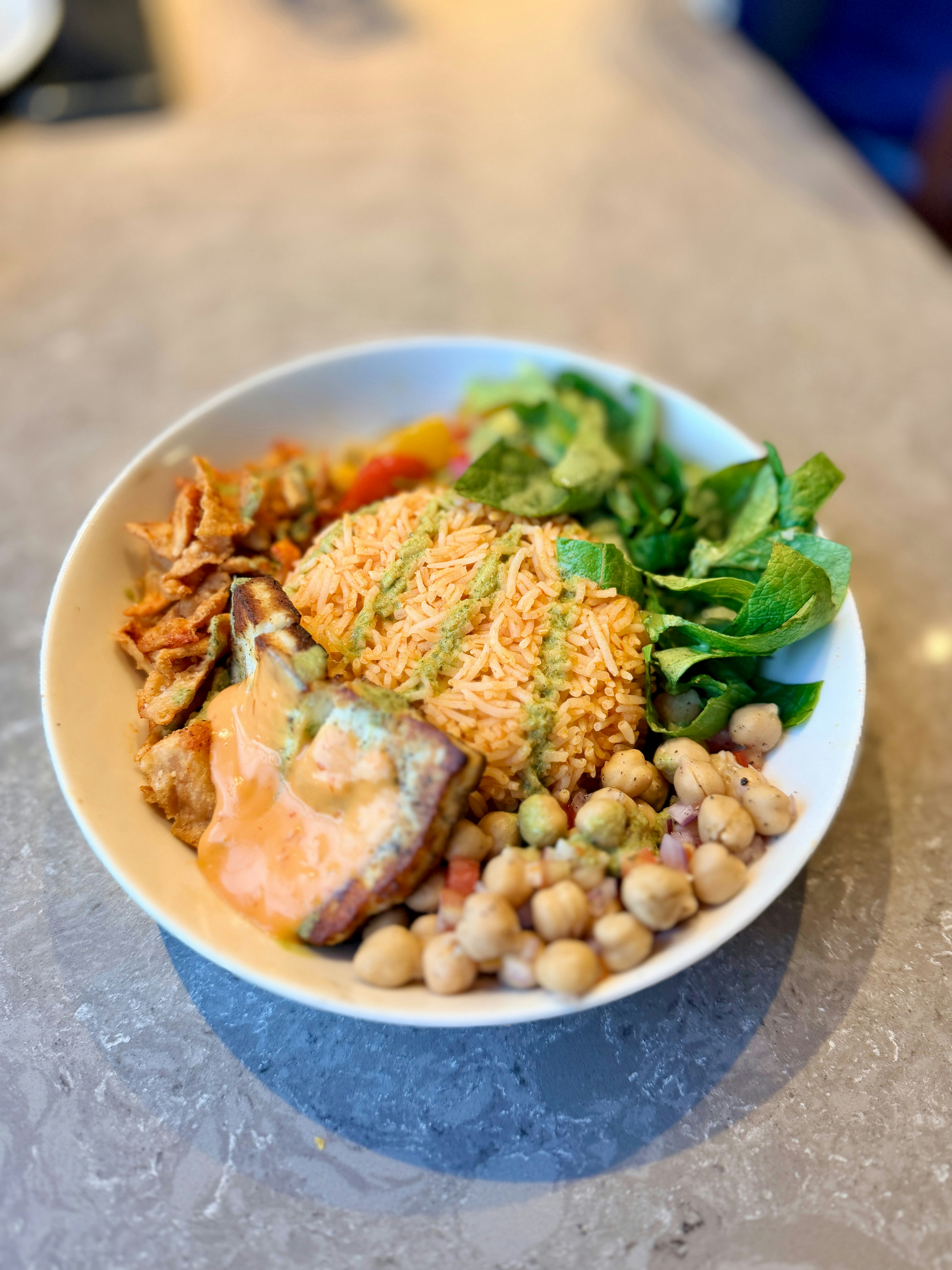 Bowl of vibrant plant-based bounty: chickpeas, greens, and spiced grains