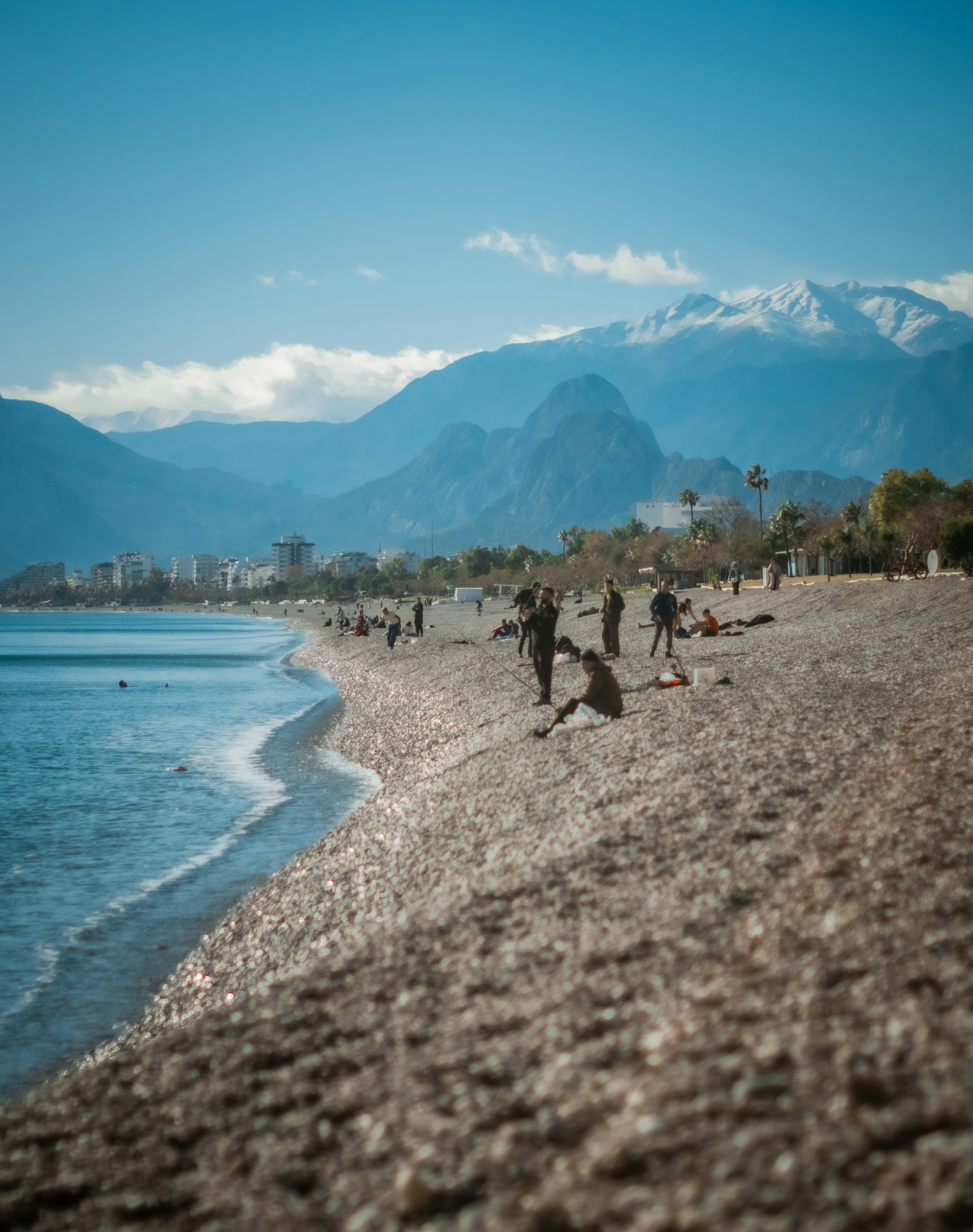 Low Tide on Marble Beach: People, Pebbles, and Mountains