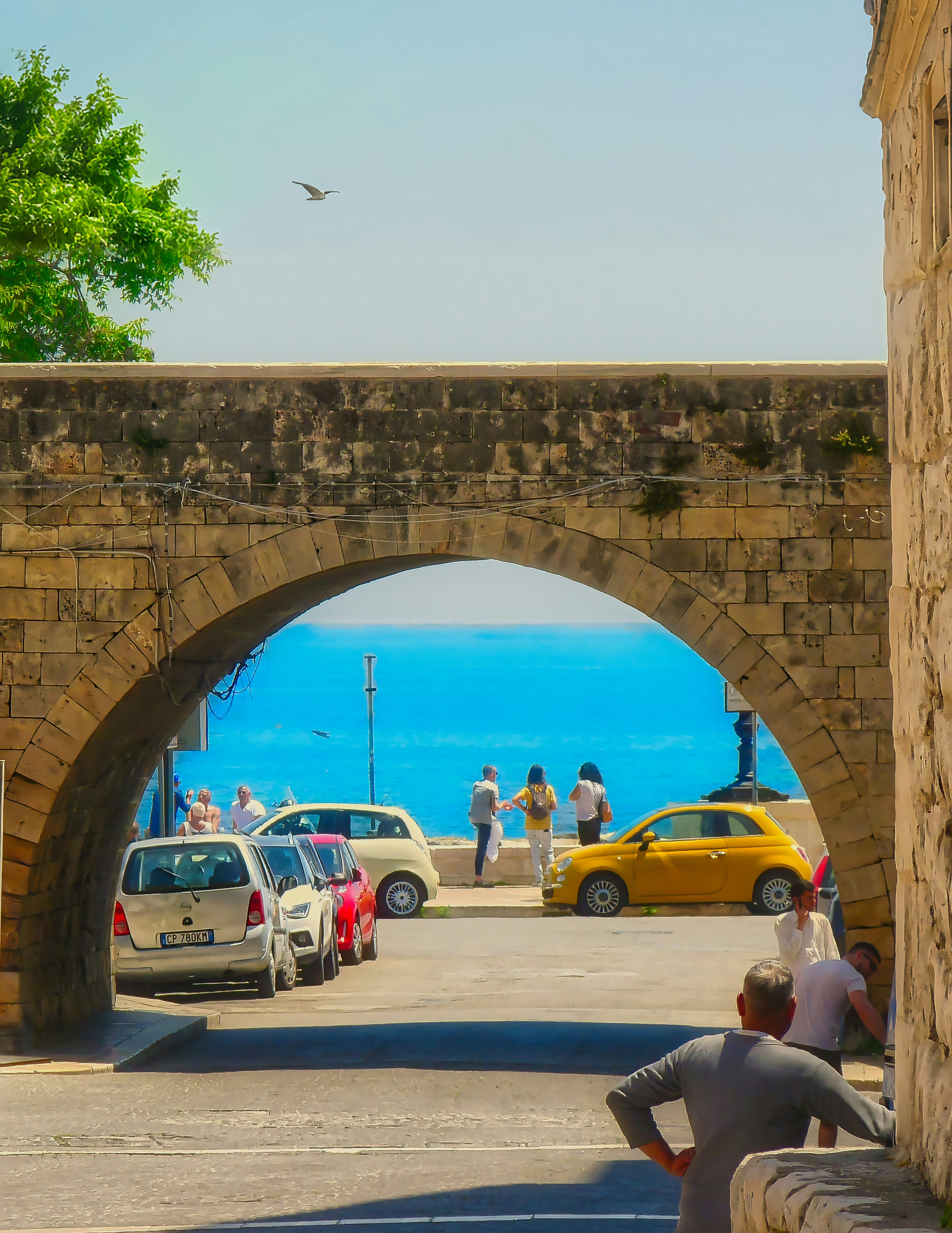 Archway to the Sea: People, Cars, and a Bright Horizon