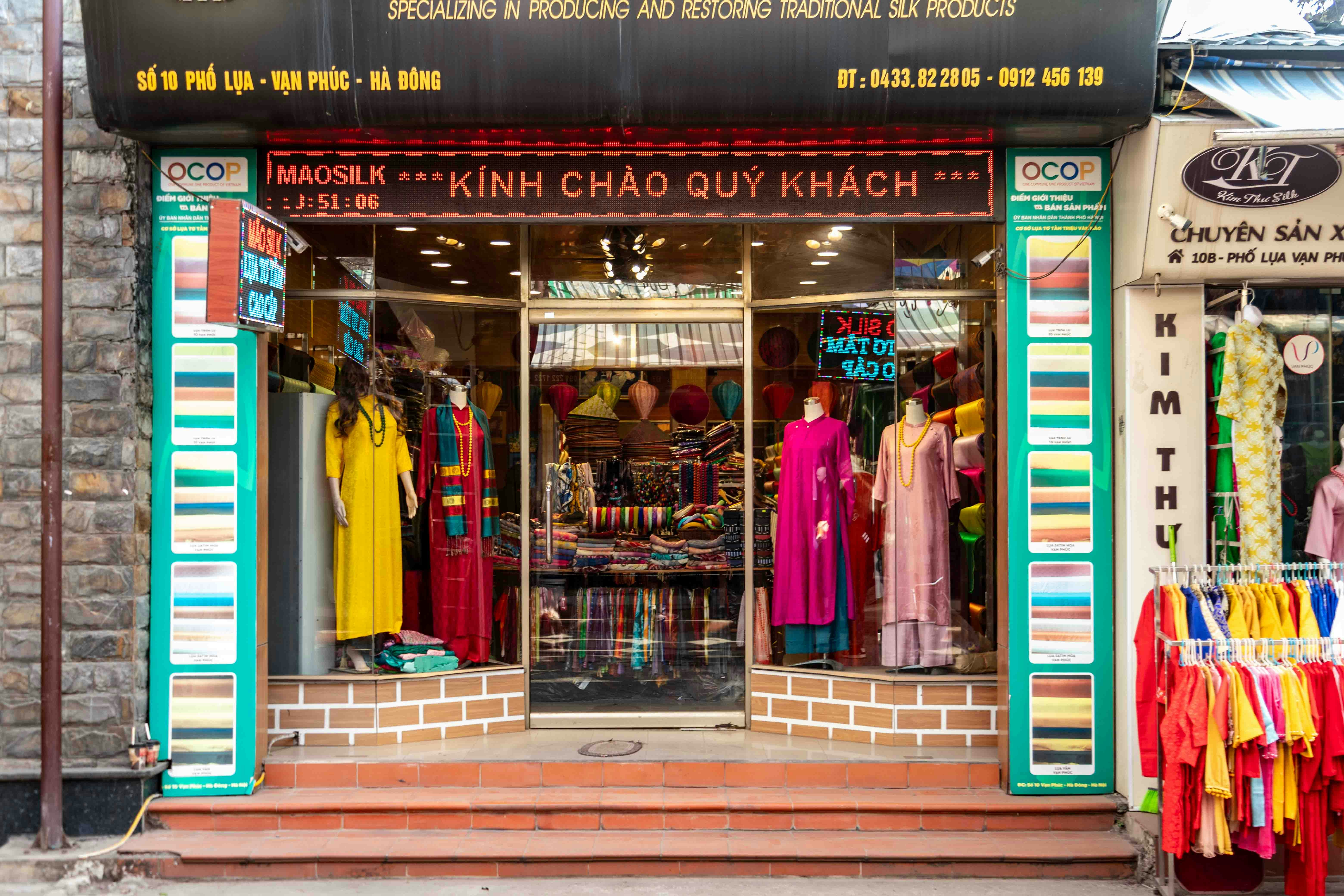 Vibrant Boutique Threshold: Colorful Garments Framed by a Traditional Shopfront
