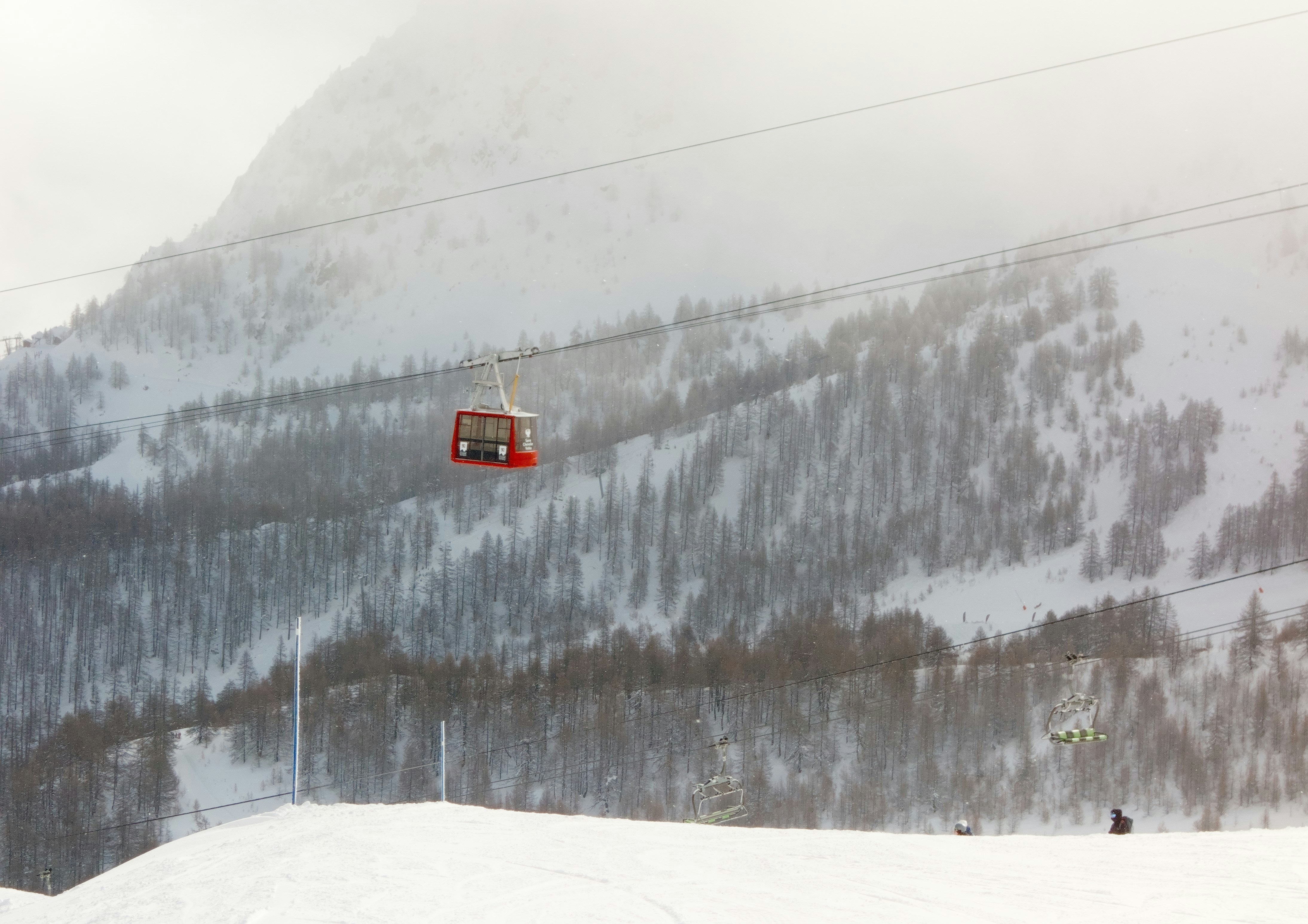 Snowbound Lift: A Lone Cable Car Draped in Mist Above Quiet Slopes