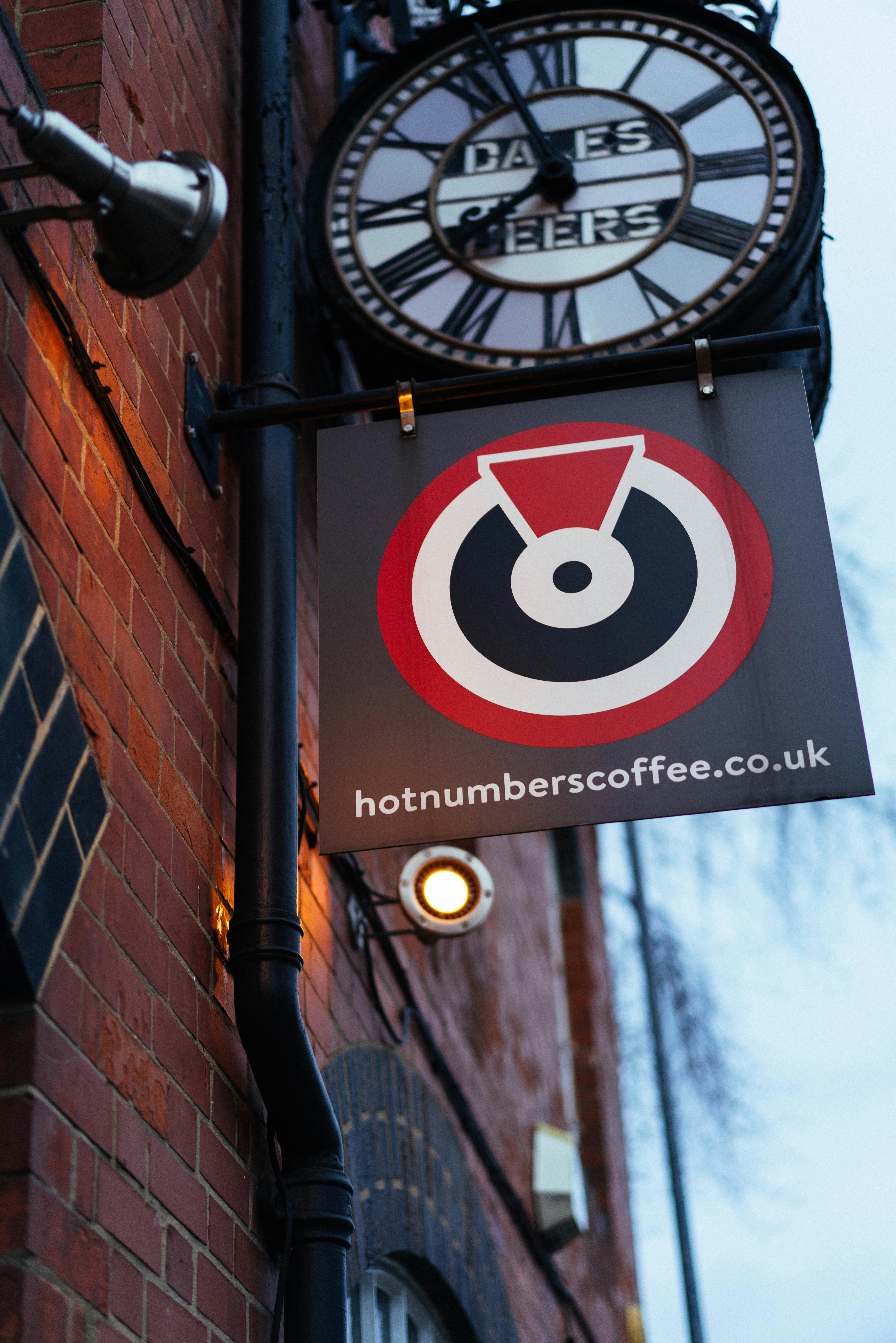 Signage in Focus: A Clock, a Coffee Logo, and Brick Alley Light