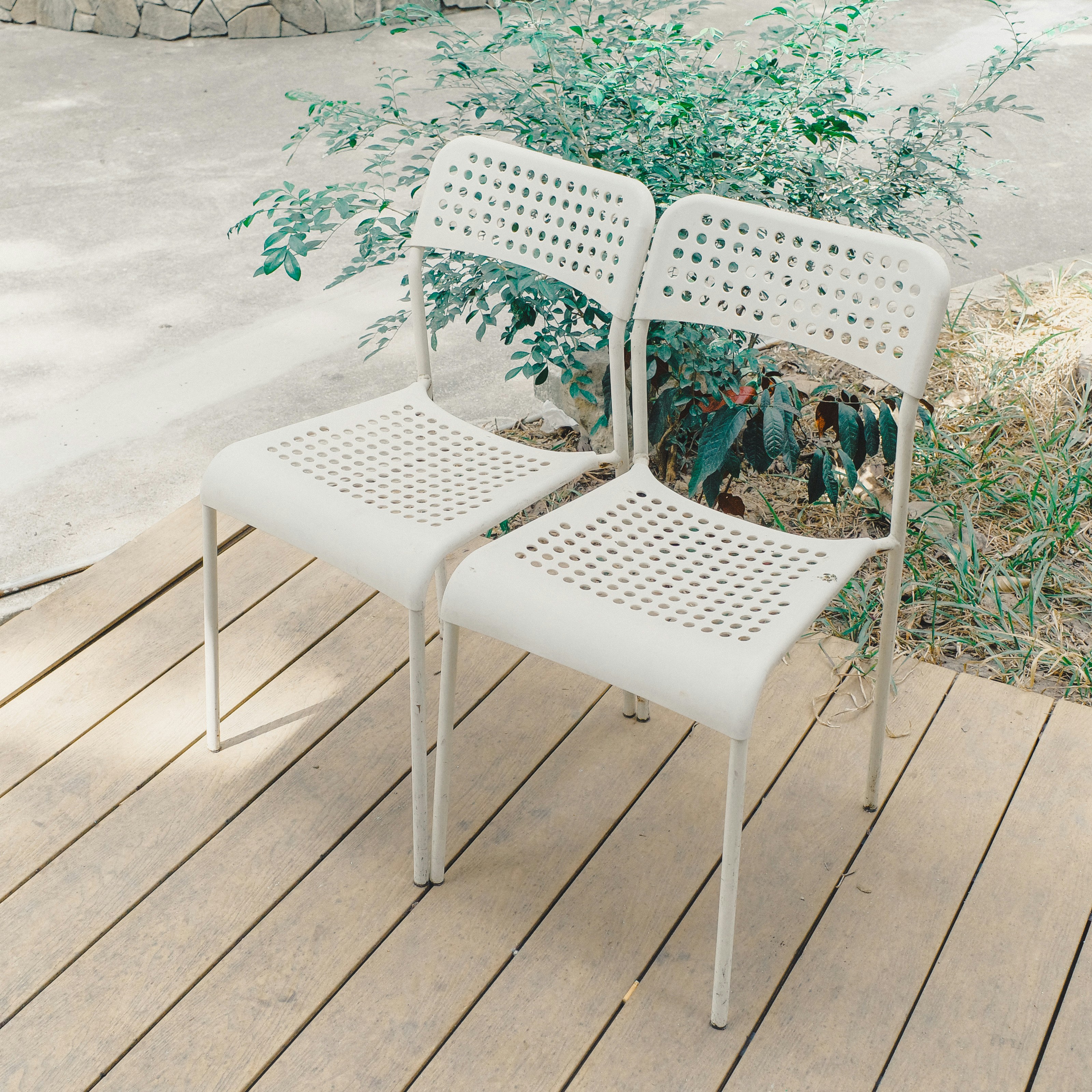 Two Minimalist White Chairs in a Quiet Outdoor Corner