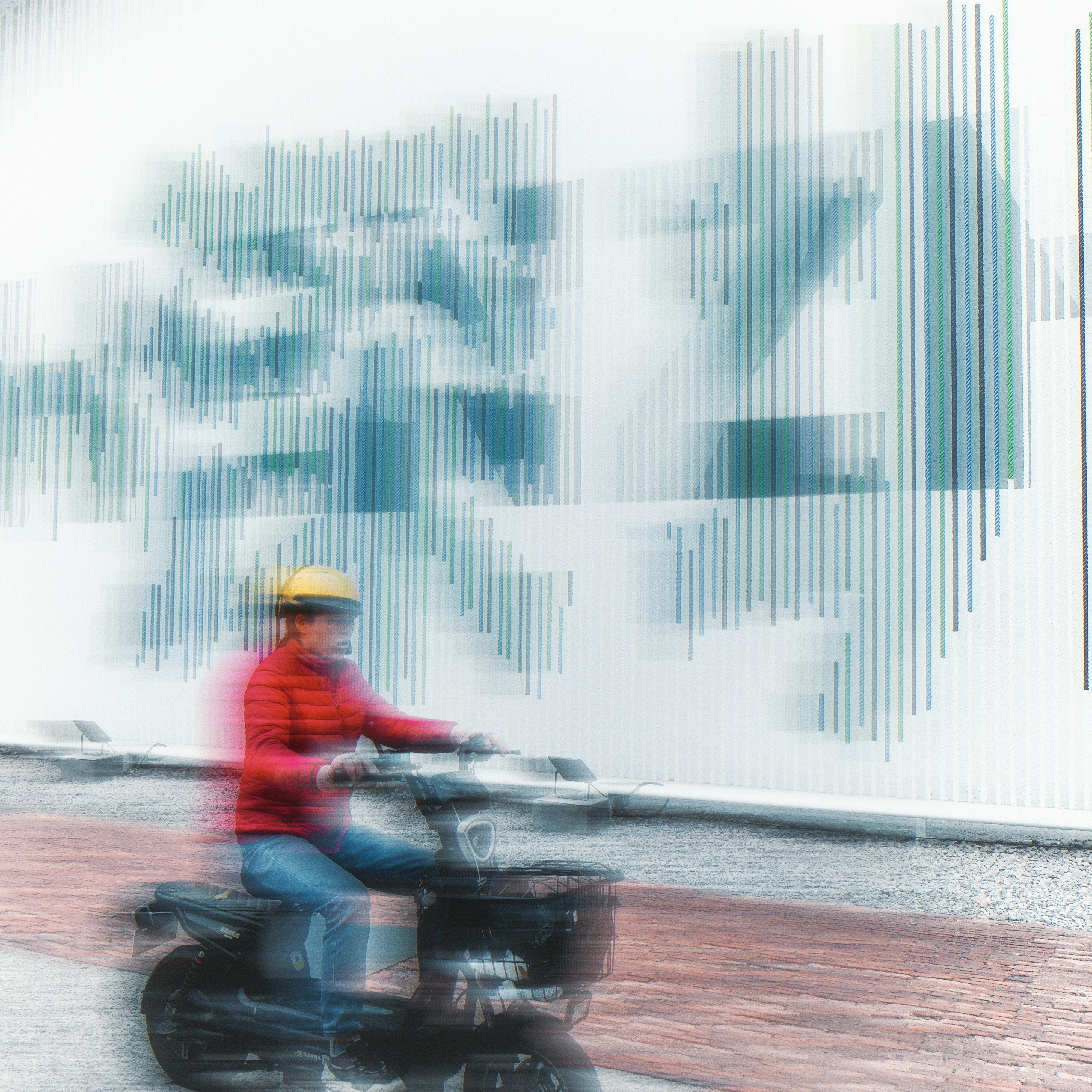 Blurred Ride: A Rider in Red on a Moving Citycape