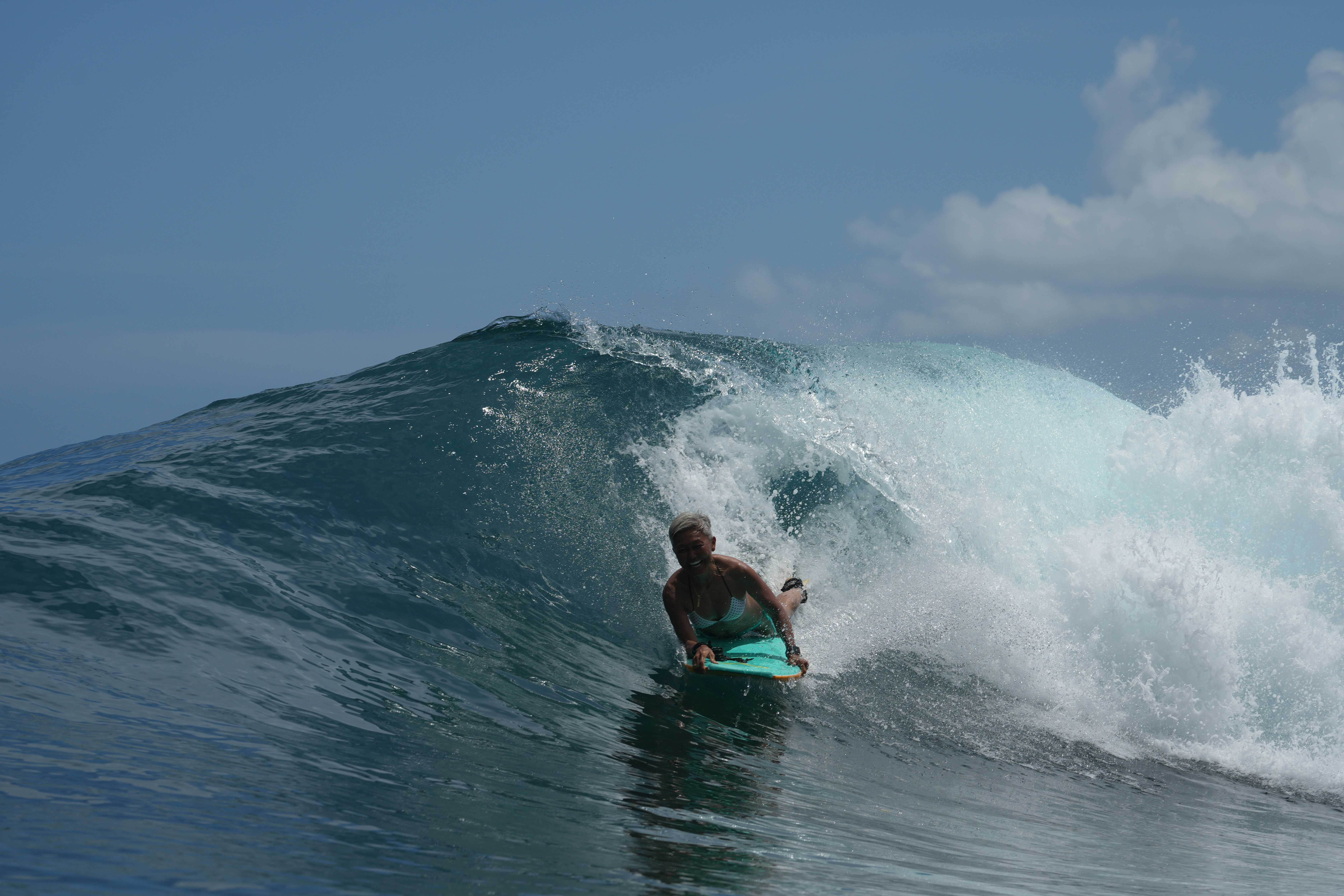 Rider carving a blue-tinted crest: a surfer mid-ride