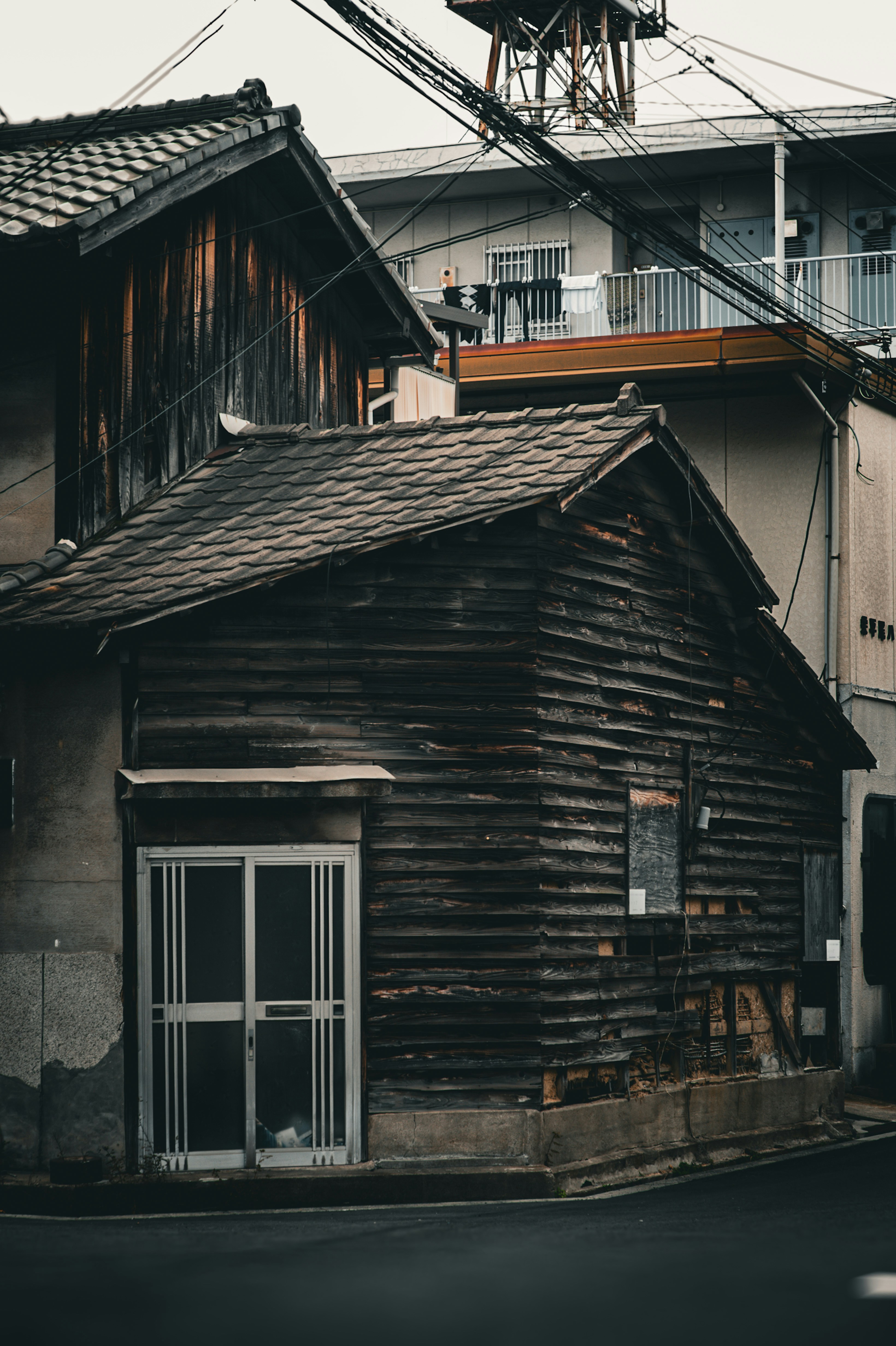Weathered wooden facade under tangled utilities