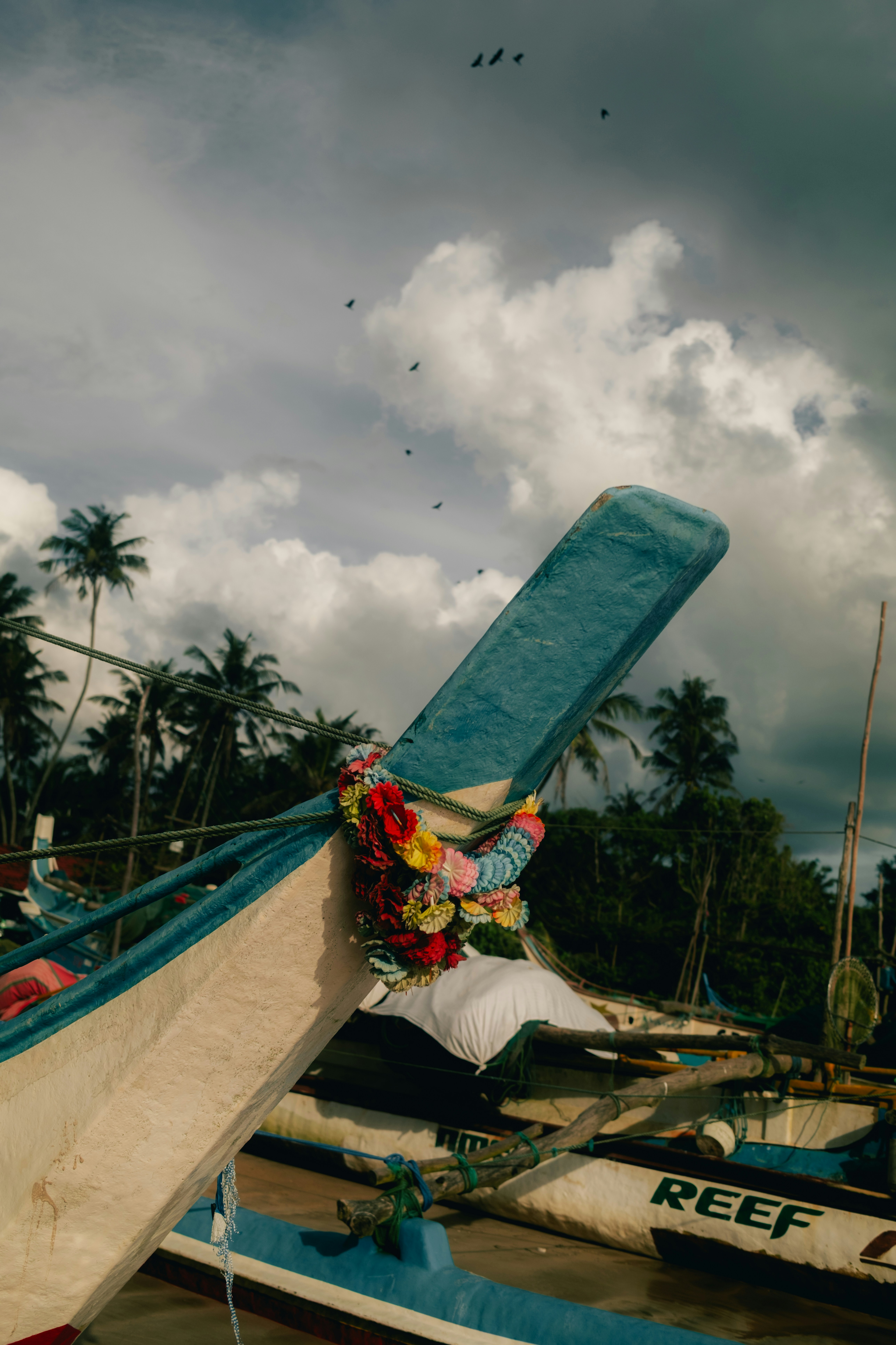 Garlanded prow under tropical sky