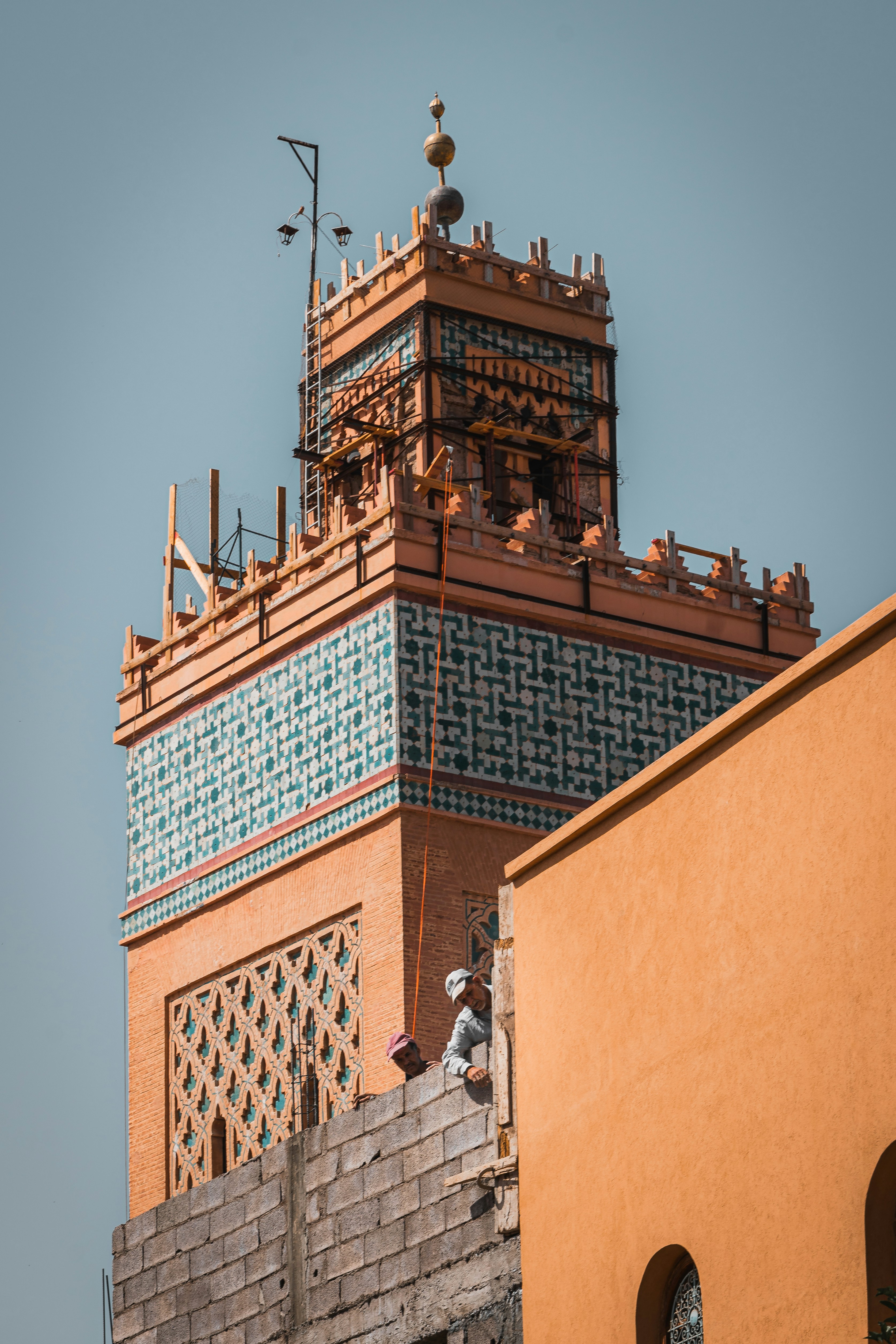 Terracotta Minaret Crown: A Distant View of Ornate Turrets and Patched Wall