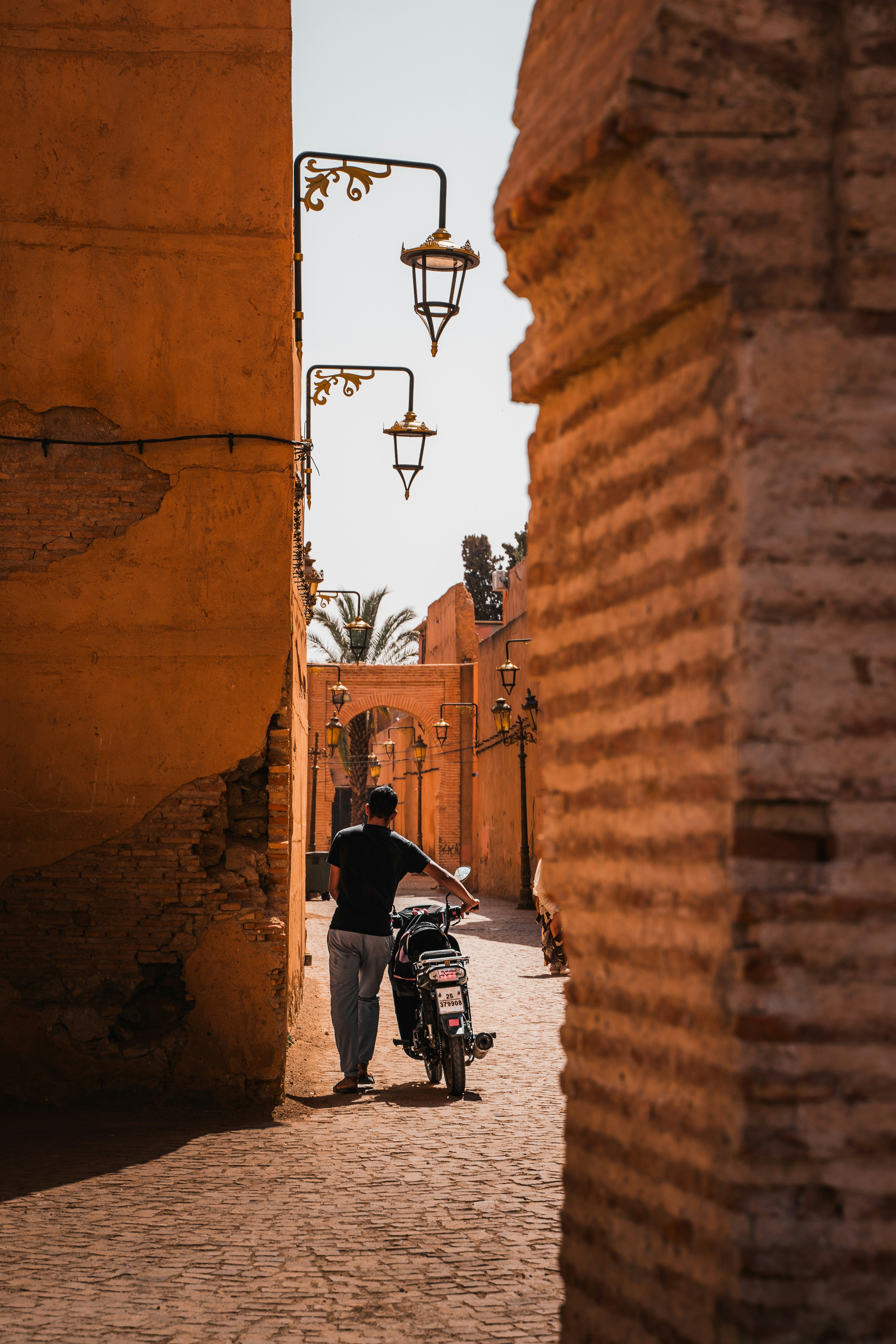 Street of Terracotta Walls: A Lone Rider in an Arcaded Alley