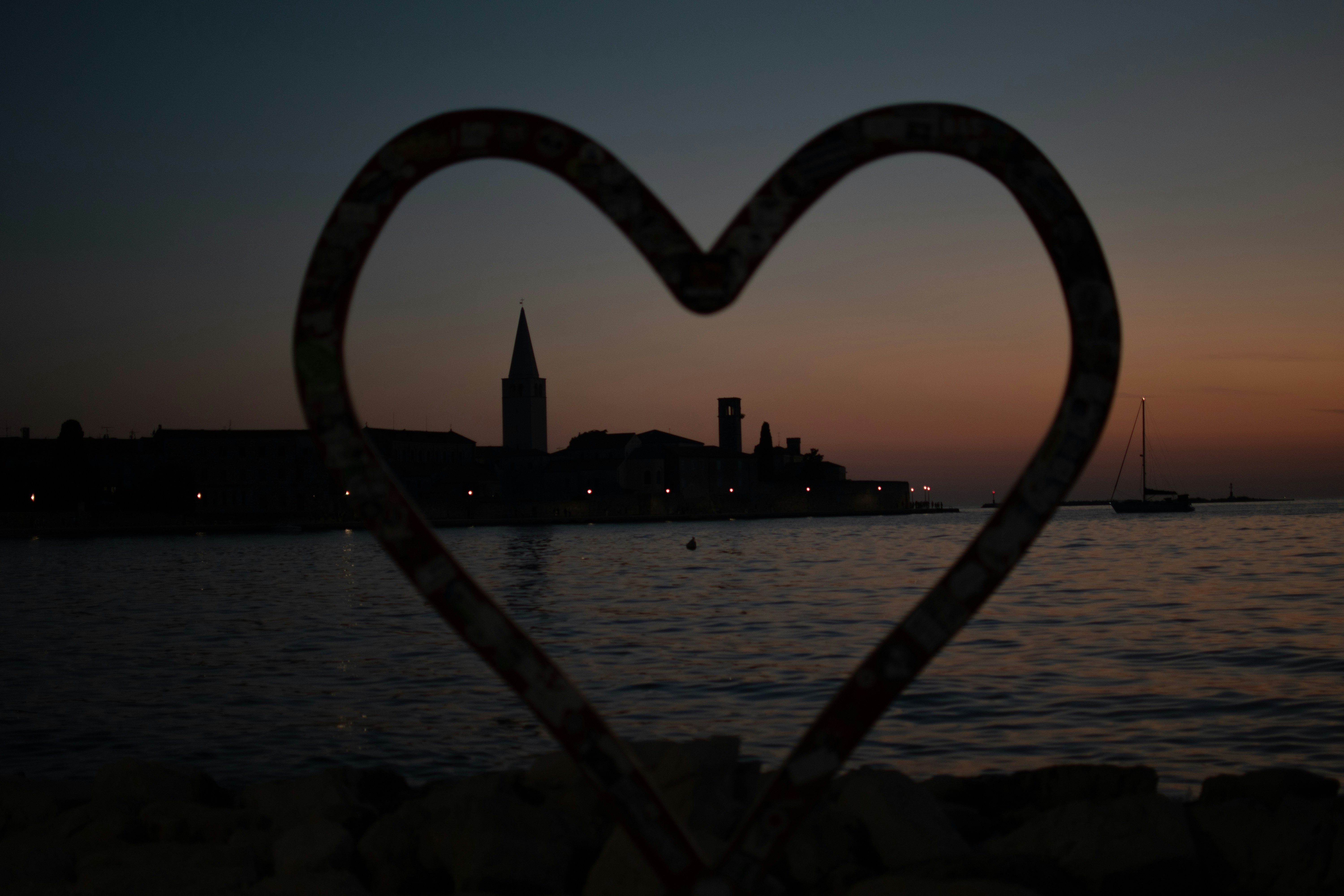 Heart of the Harbor: Sunset Silhouette Through a Metal Frame