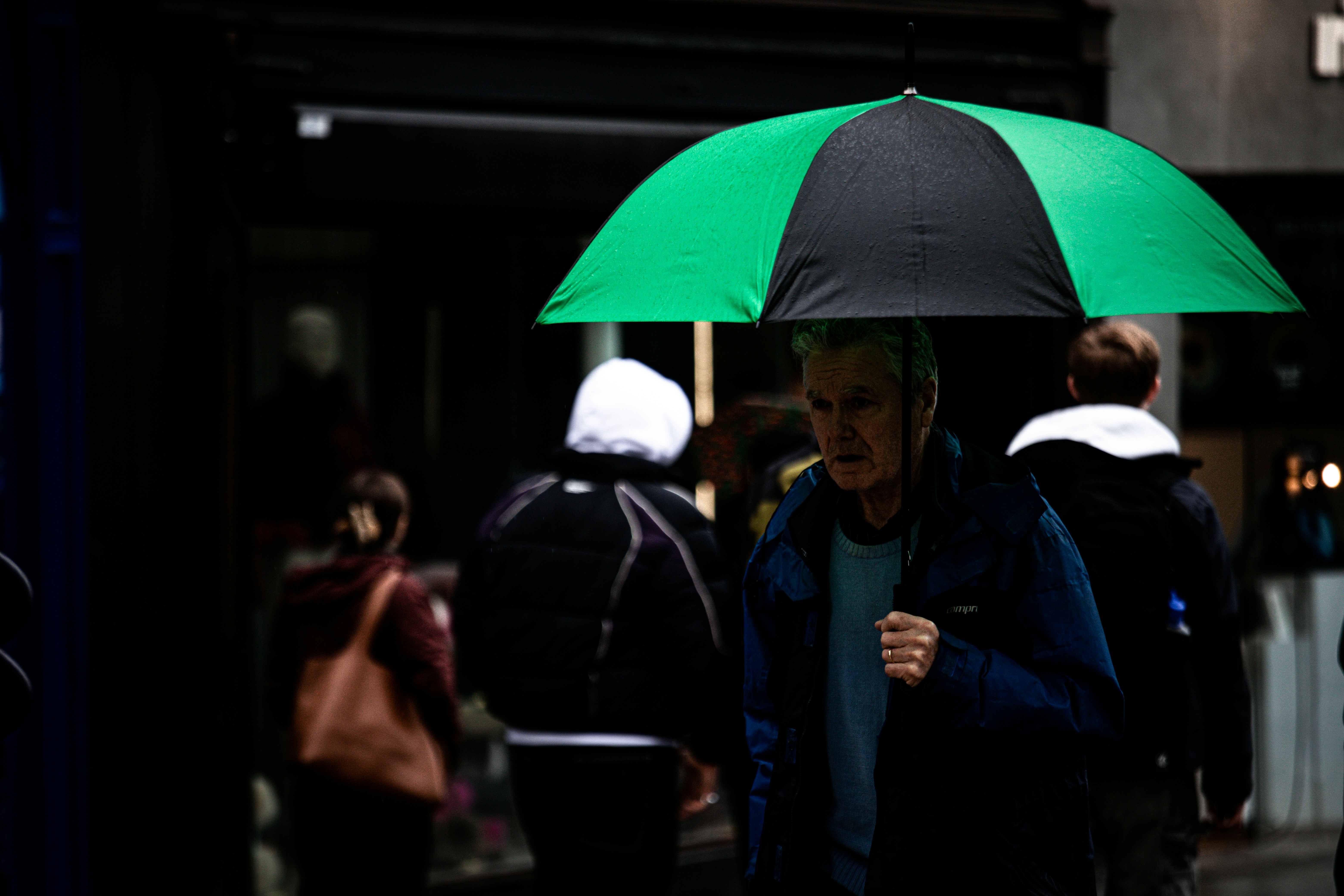 Green-and-Black Umbrella Framed by Pedestrian Alley