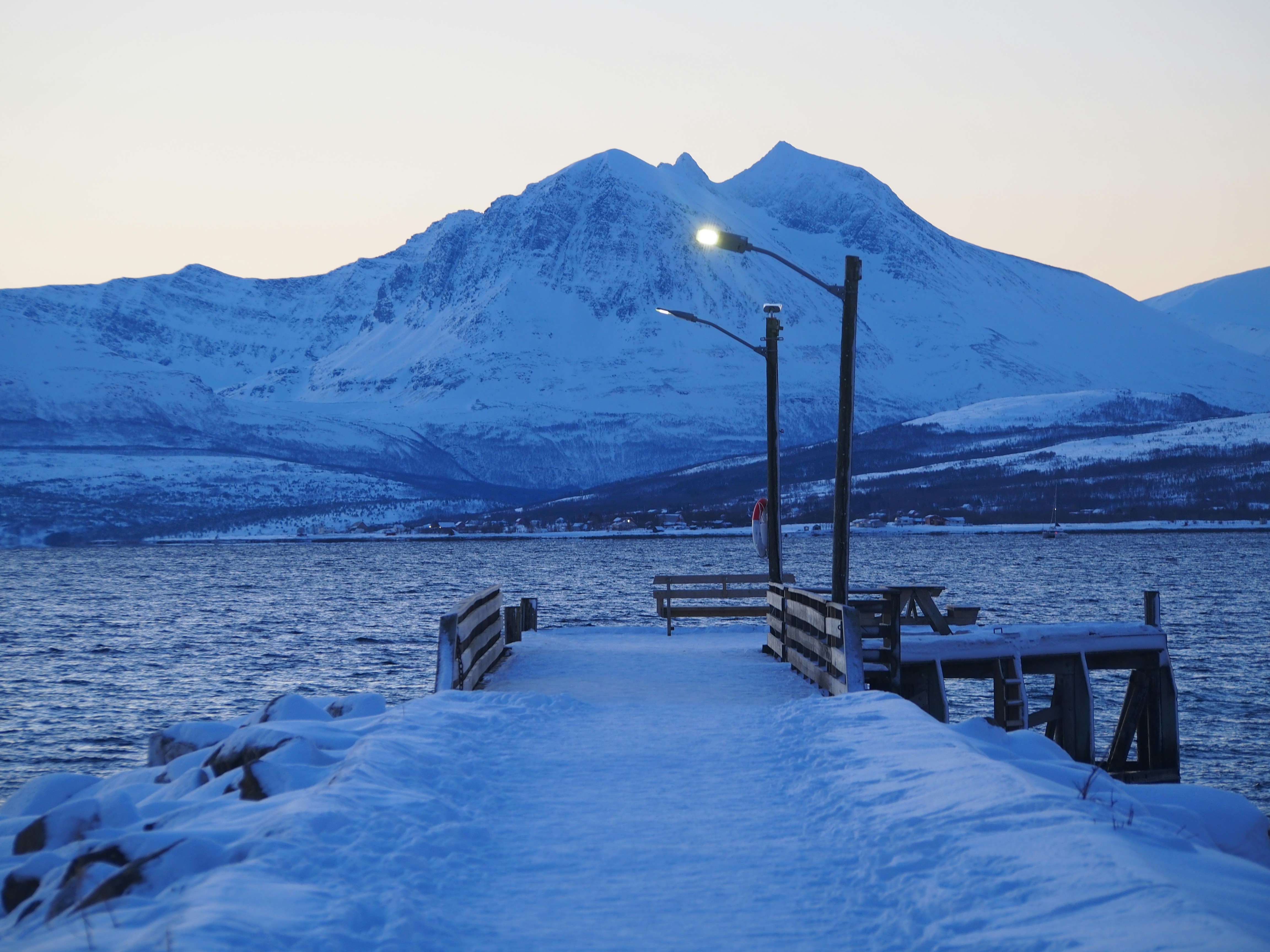 Snow-Quiet Pier Reaching Toward Foamy Mountains
