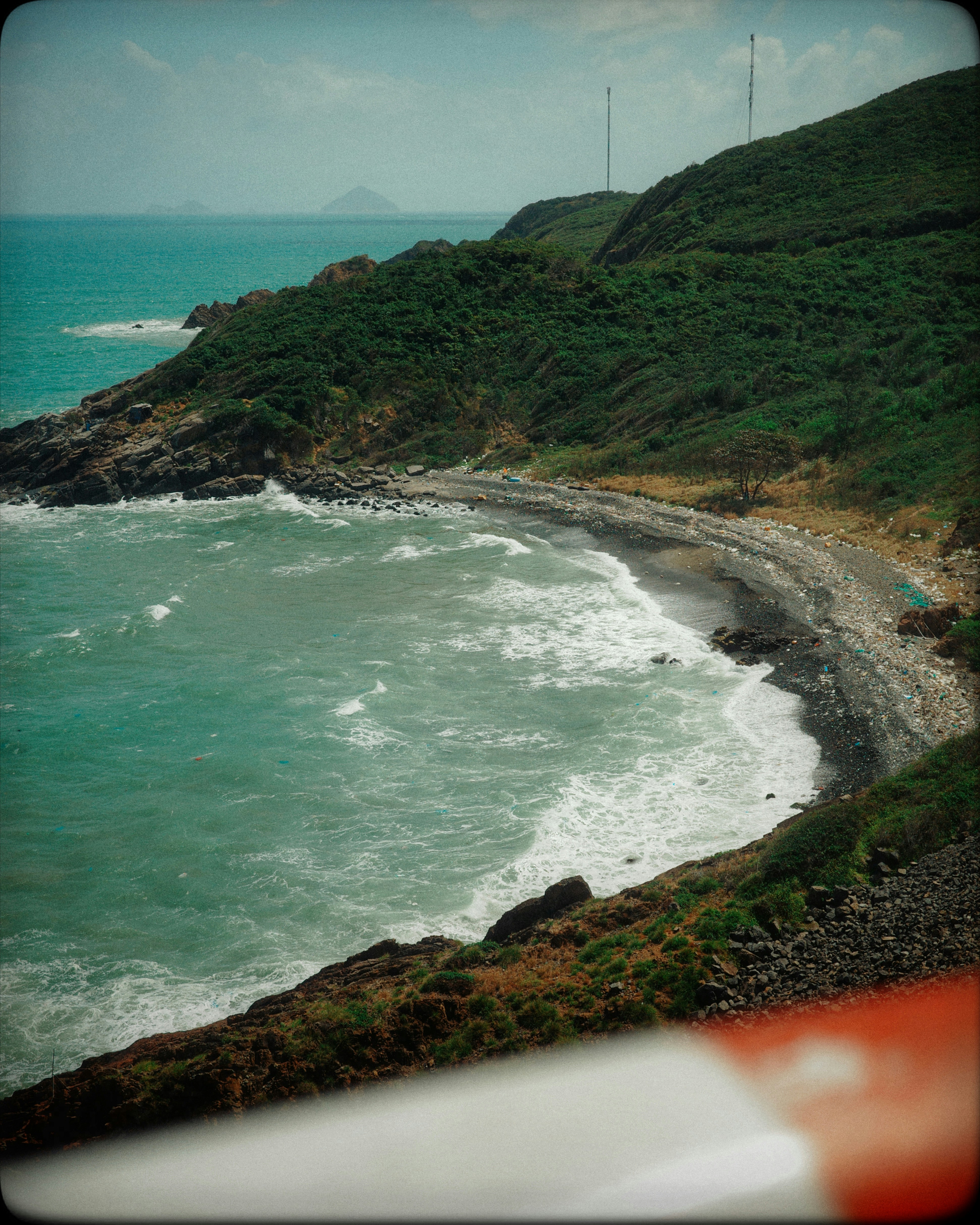 Cove on the Green Slope: Coastal Curve Under Gentle Clouds