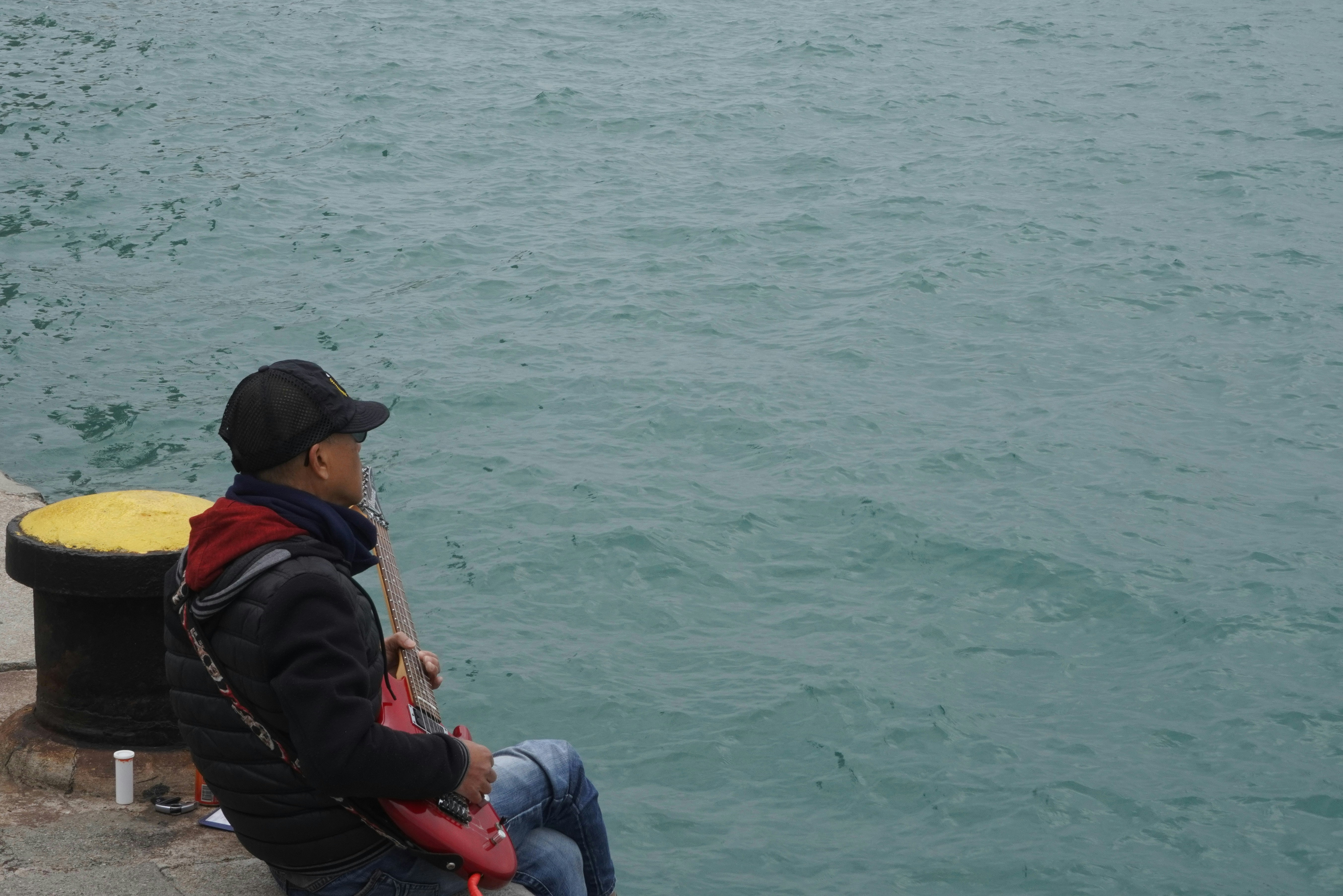 Sea-side guitarist at the edge of calm blue