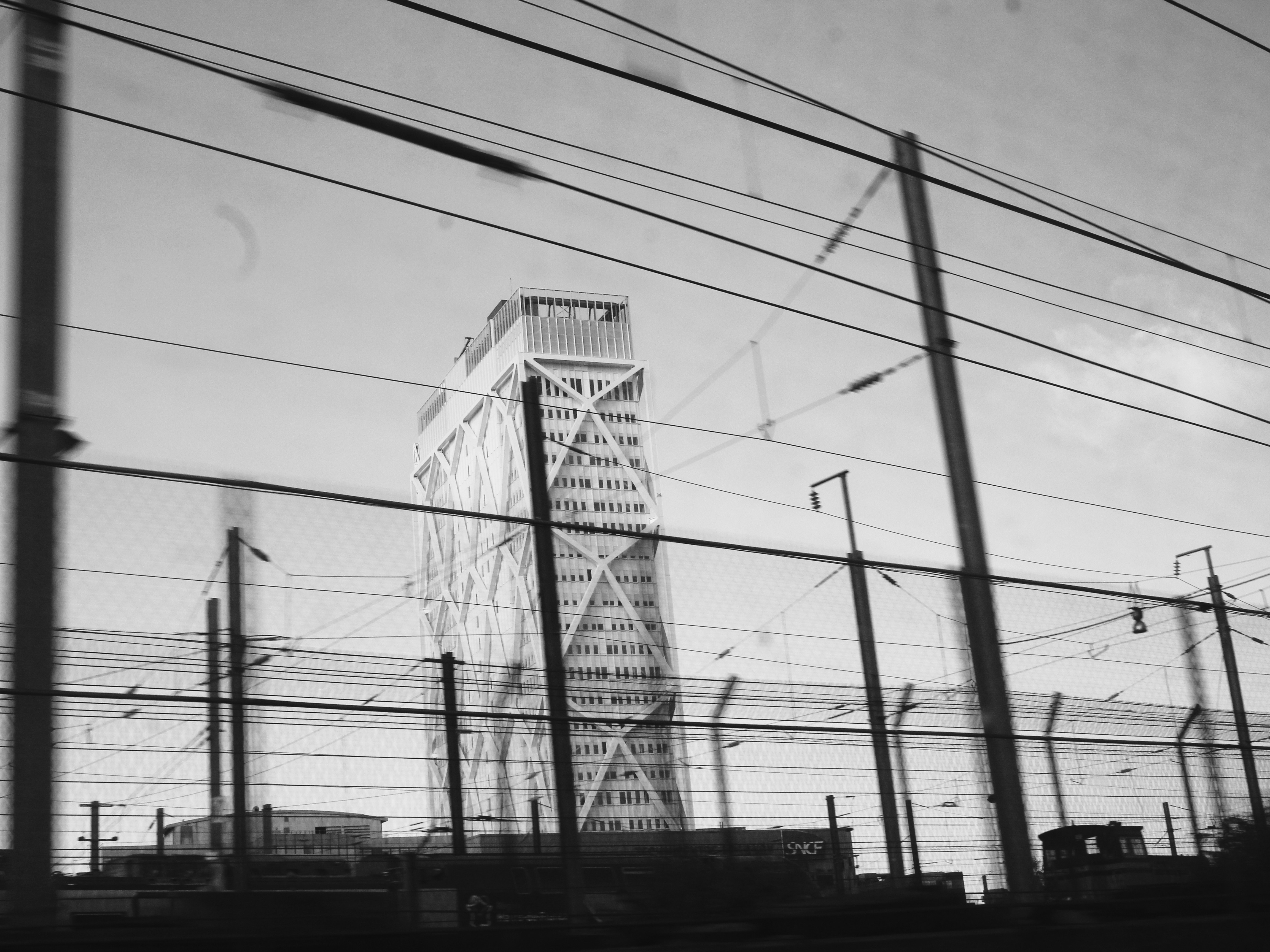 Tower behind the wires: an industrial skyline in monochrome