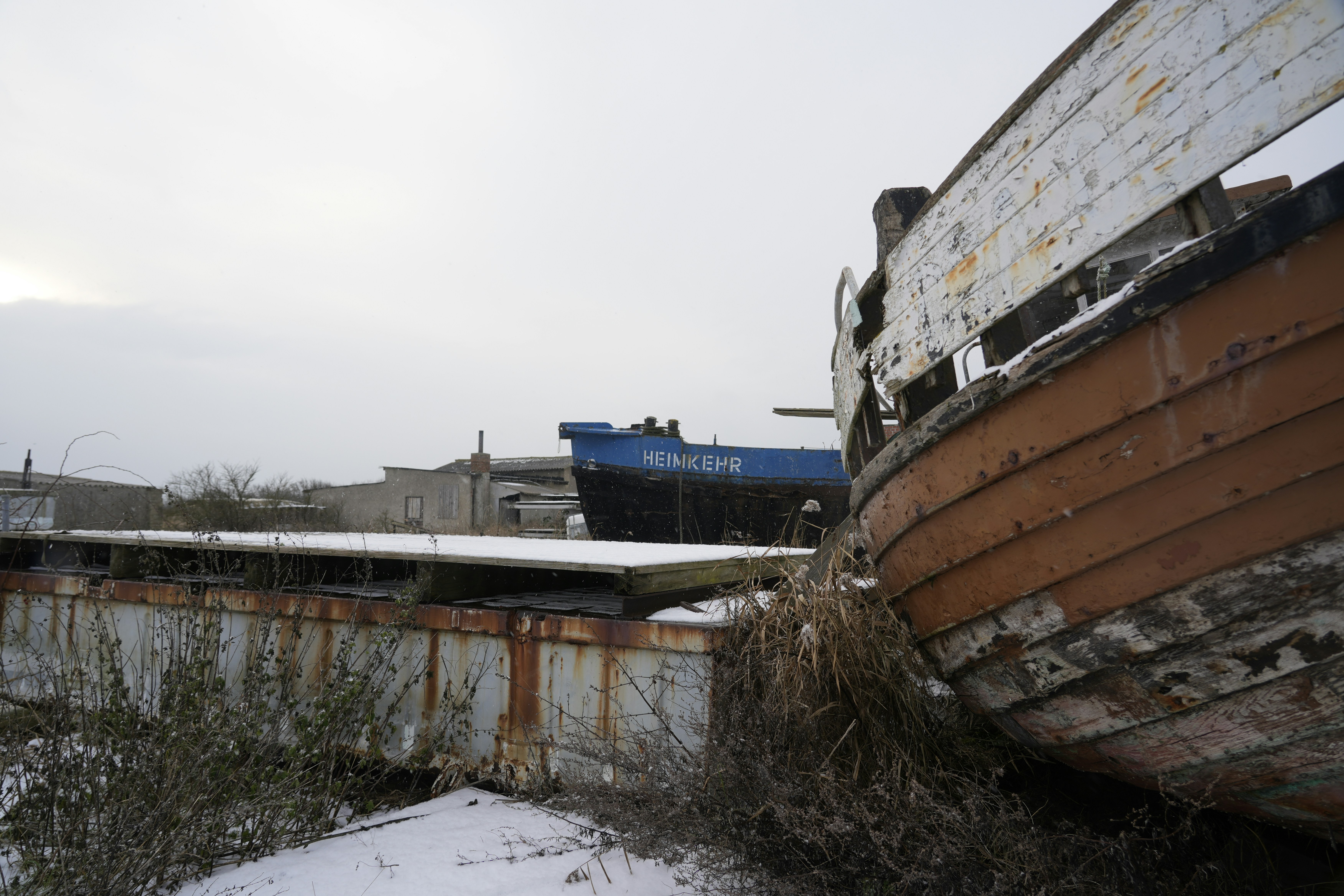 Weathered hulls and blue cargo among forgotten docks