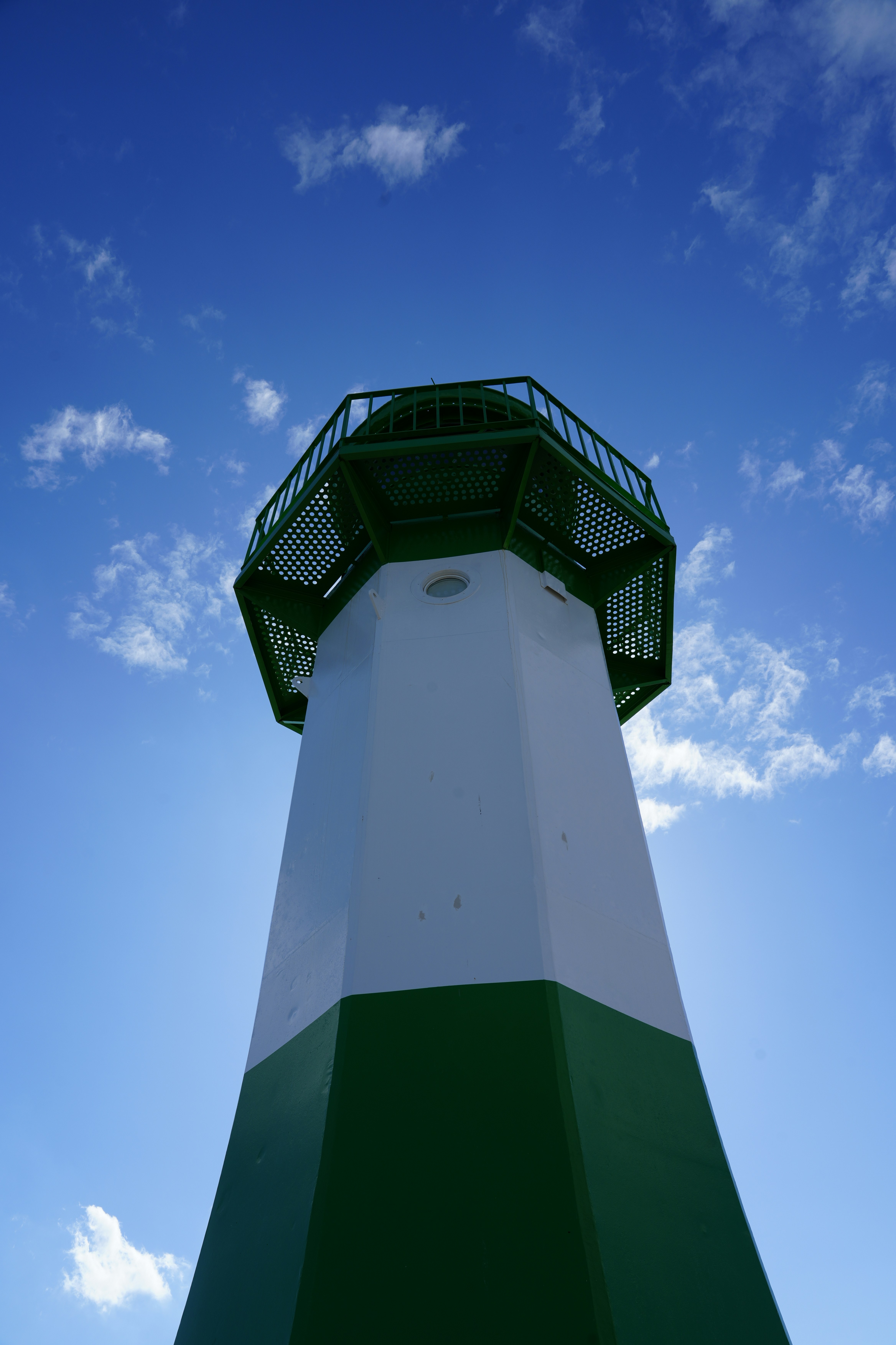 Upward Gaze: The Green-Topped Beacon Reaching Toward a Clear Sky