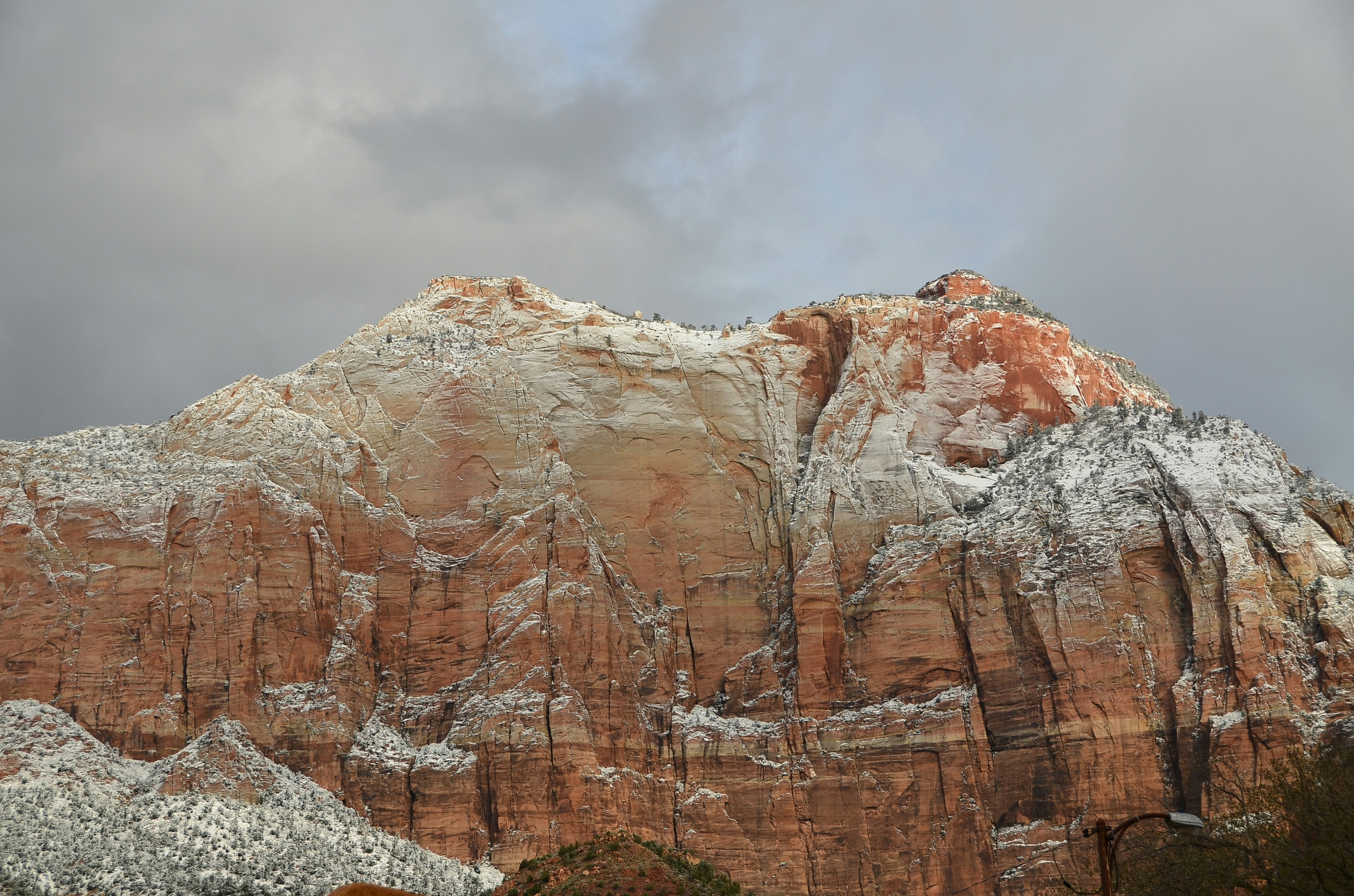 Snow-dusted red cliff face under moody sky