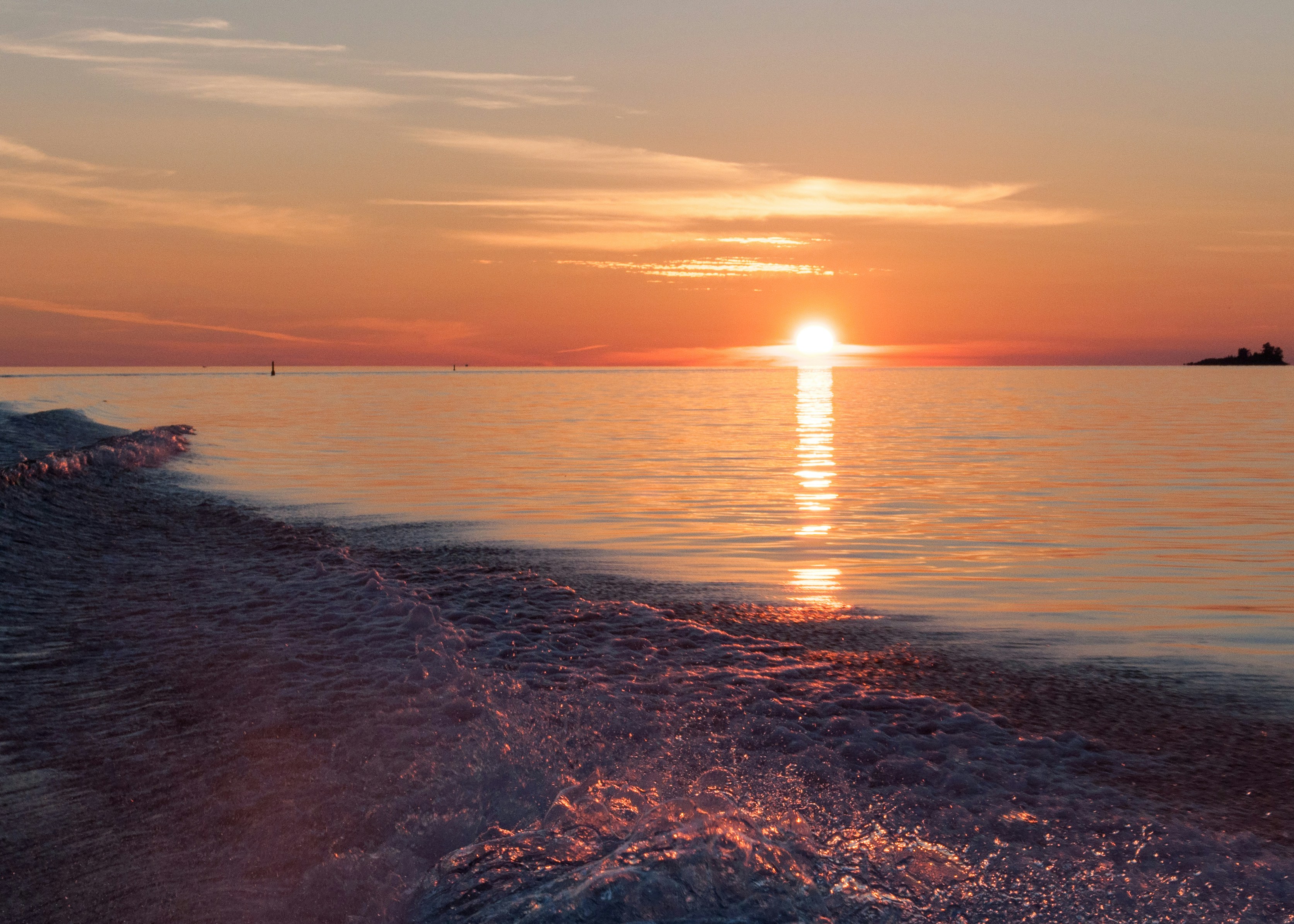 Sunlit Wake: A Gentle Ocean Sunset Leaving Velvet Foam in Its Wake
