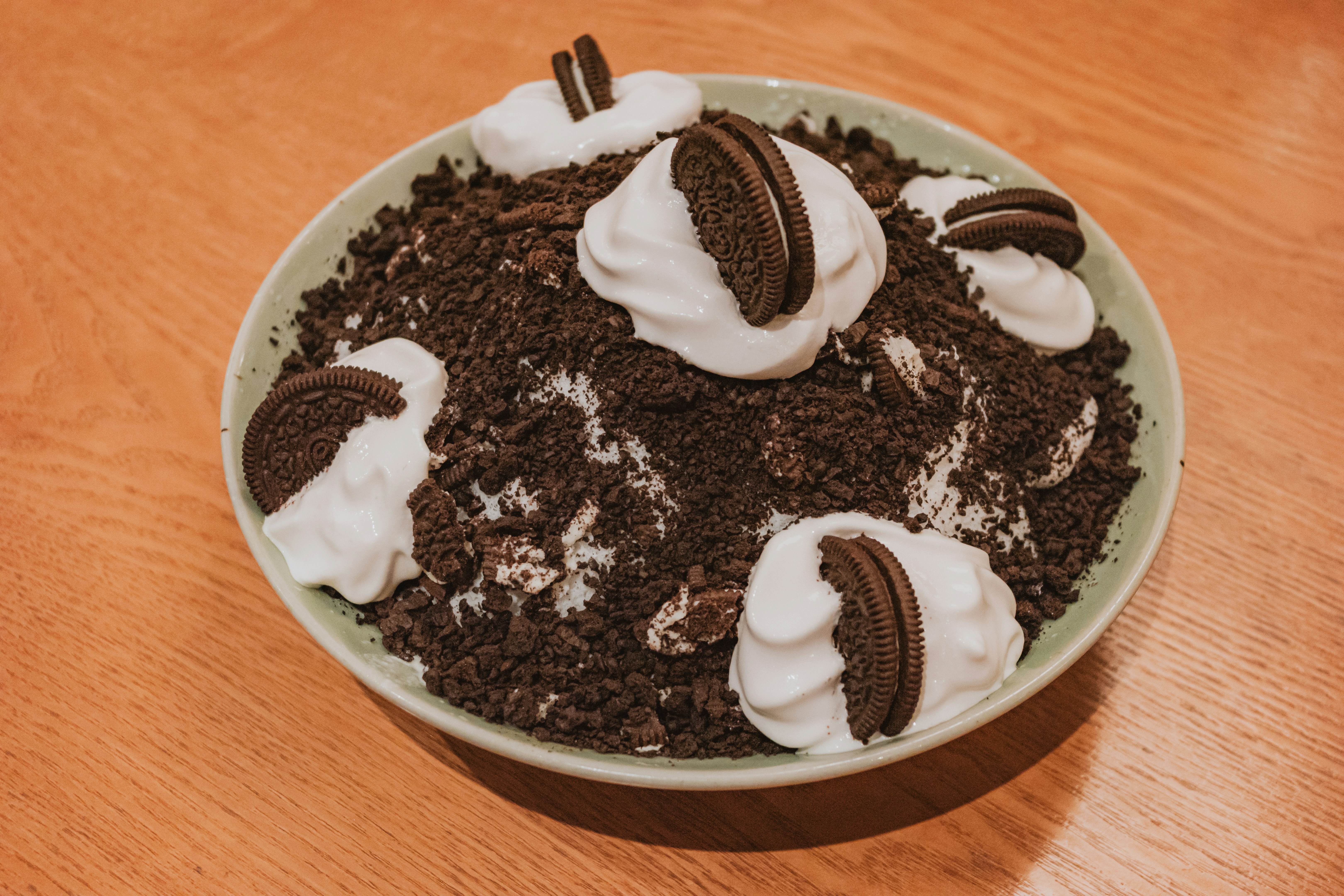 A bowl of cookies and cream dessert with whipped cream