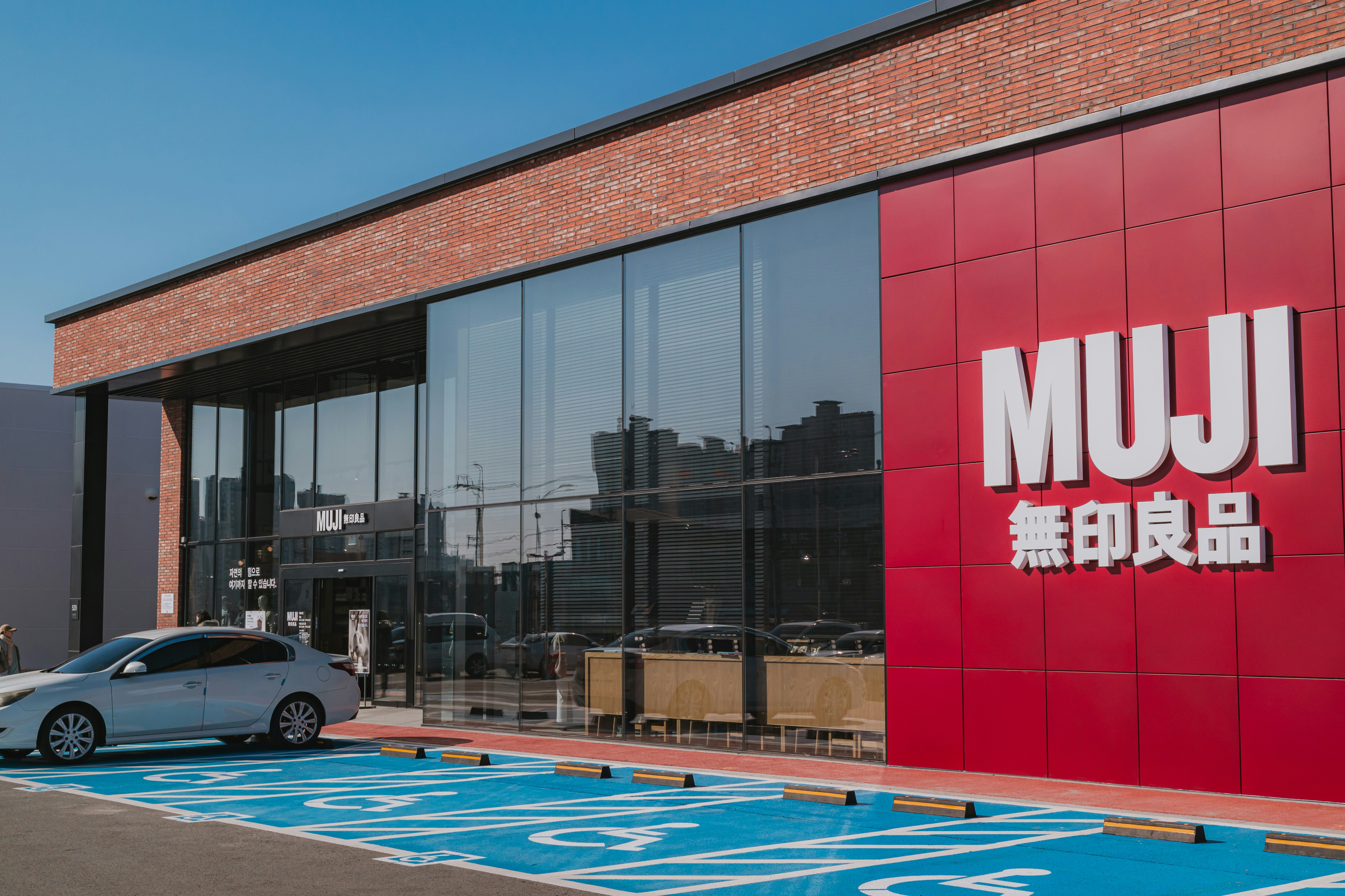 Muji store exterior with a car parked