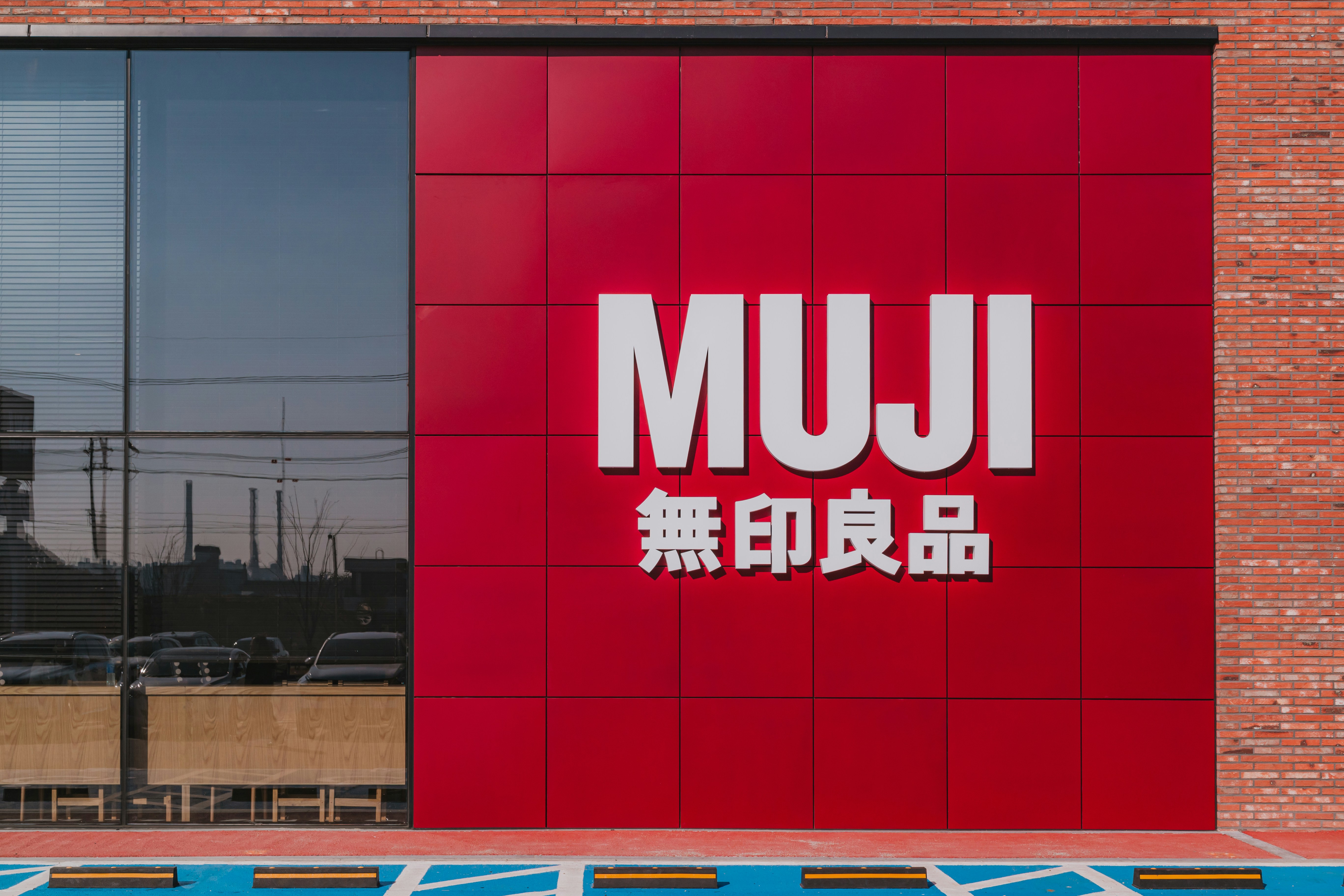 Muji store exterior with red wall and logo