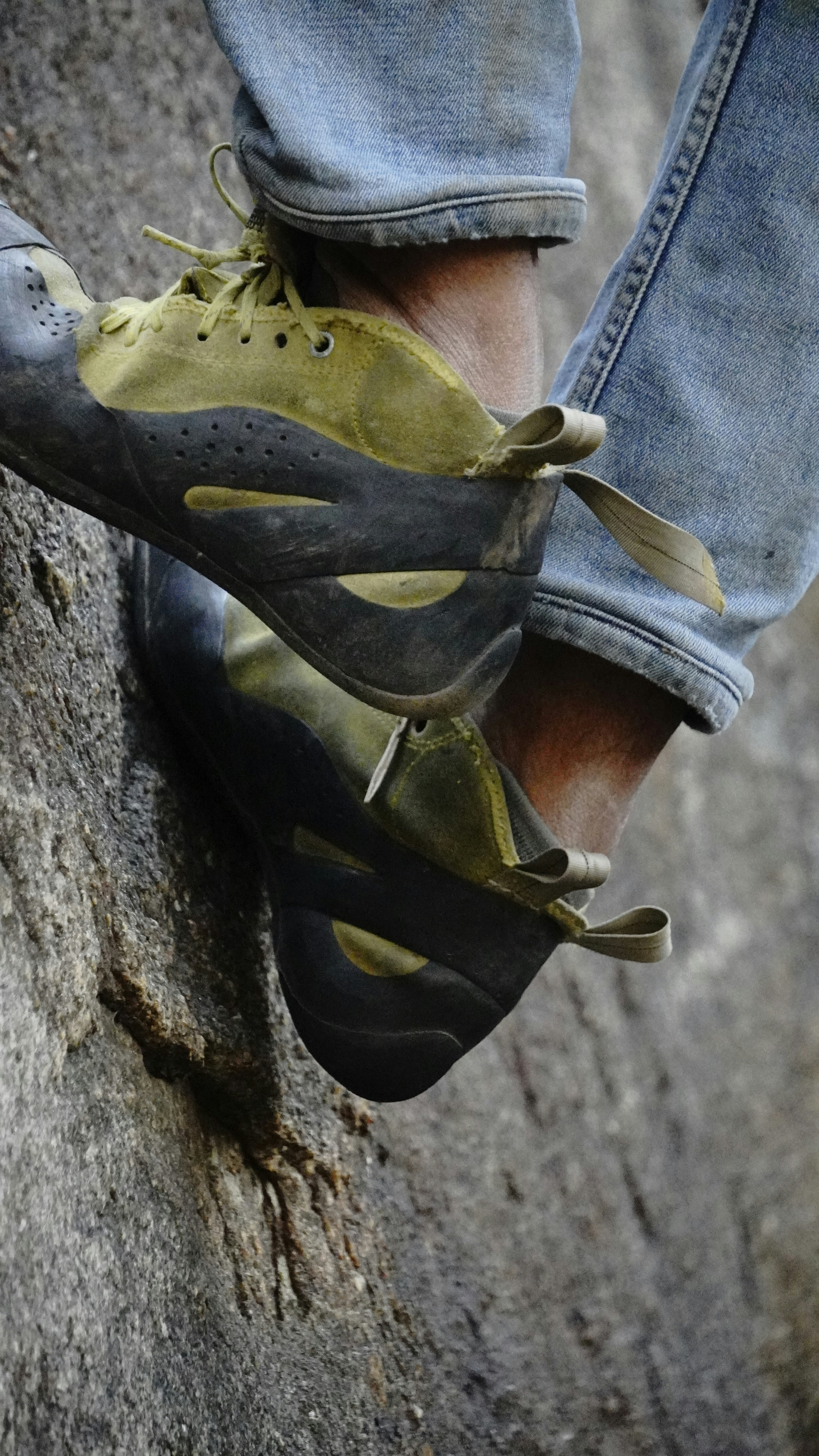 Climbing Footsteps: Worn Green Sneakers Clinging to a Rock Face