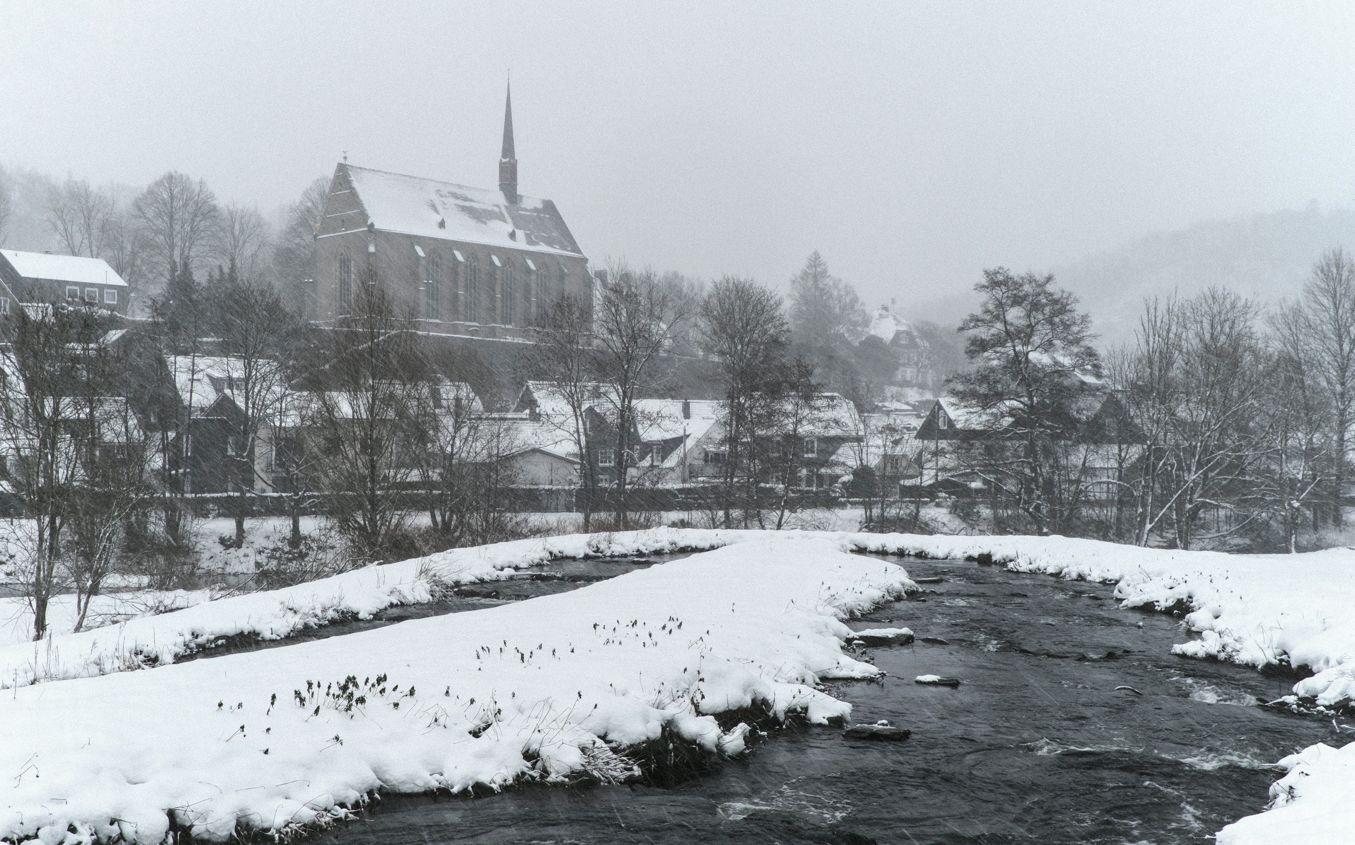 Snowbound Village Church Overlooking a Frozen Stream