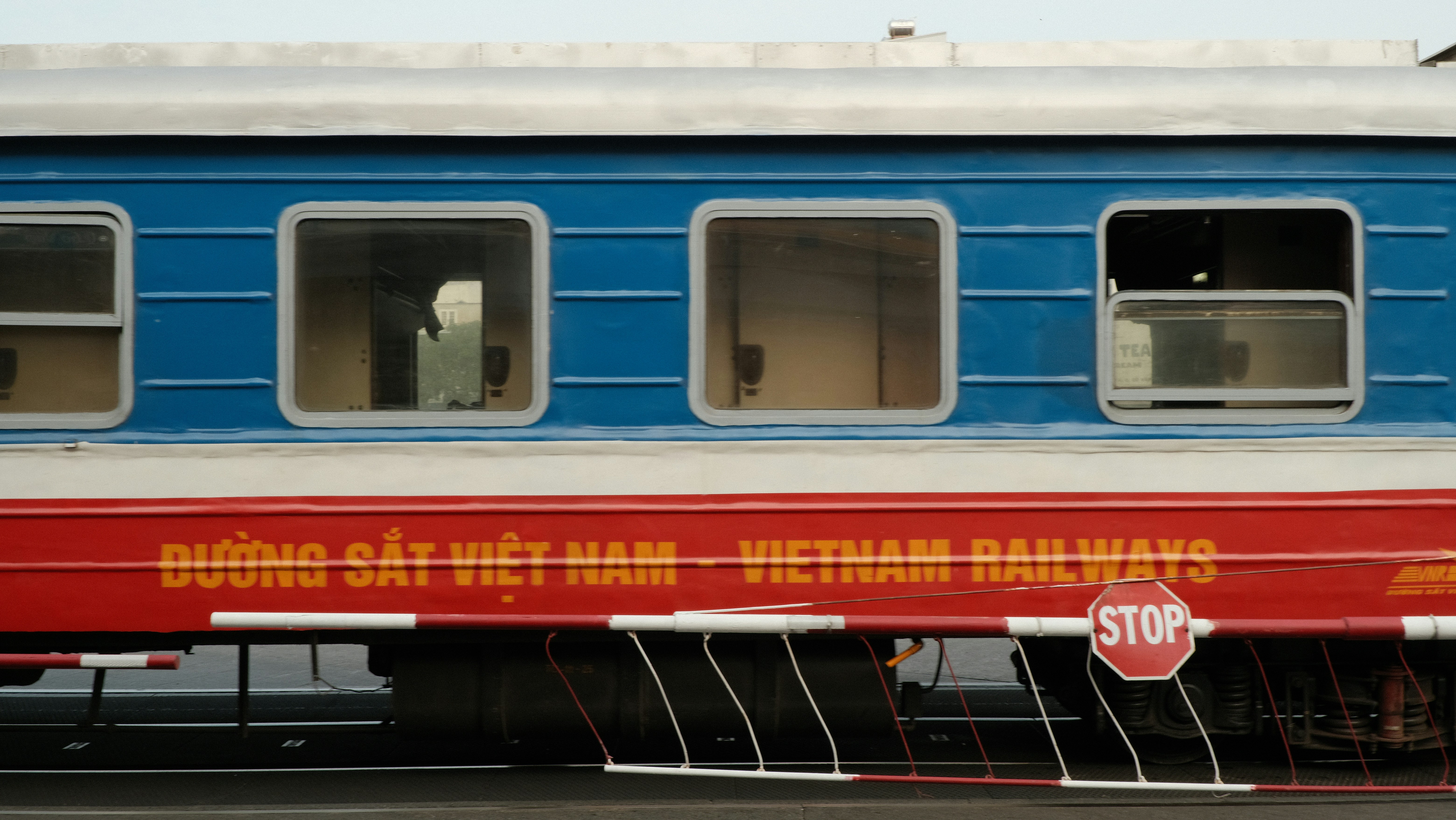 Bannered Rails: A Blue Car with Red Slogan Drifts Across the Frame