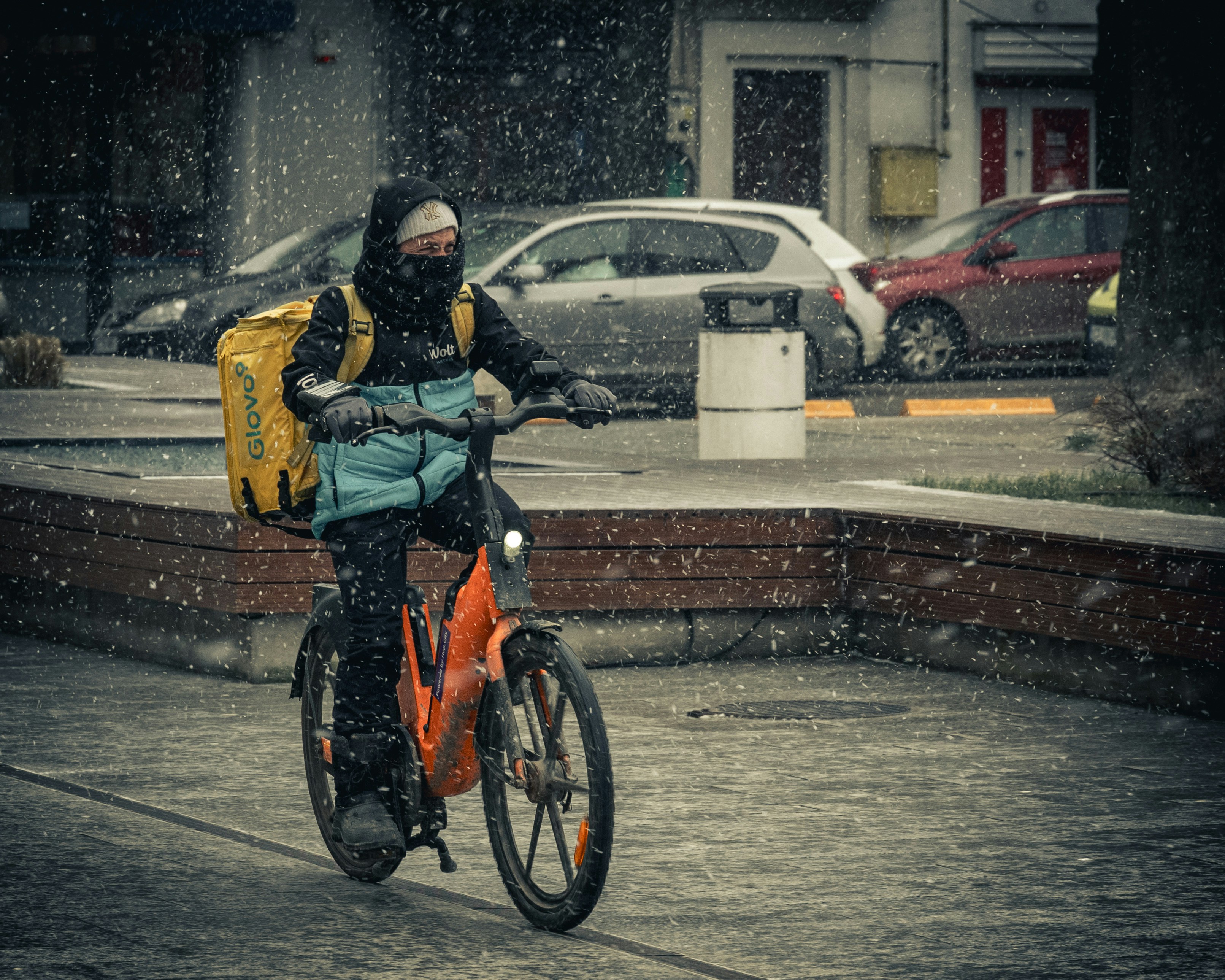 Cyclist in Snow: A Dark-Tinted Ride to the City Edge