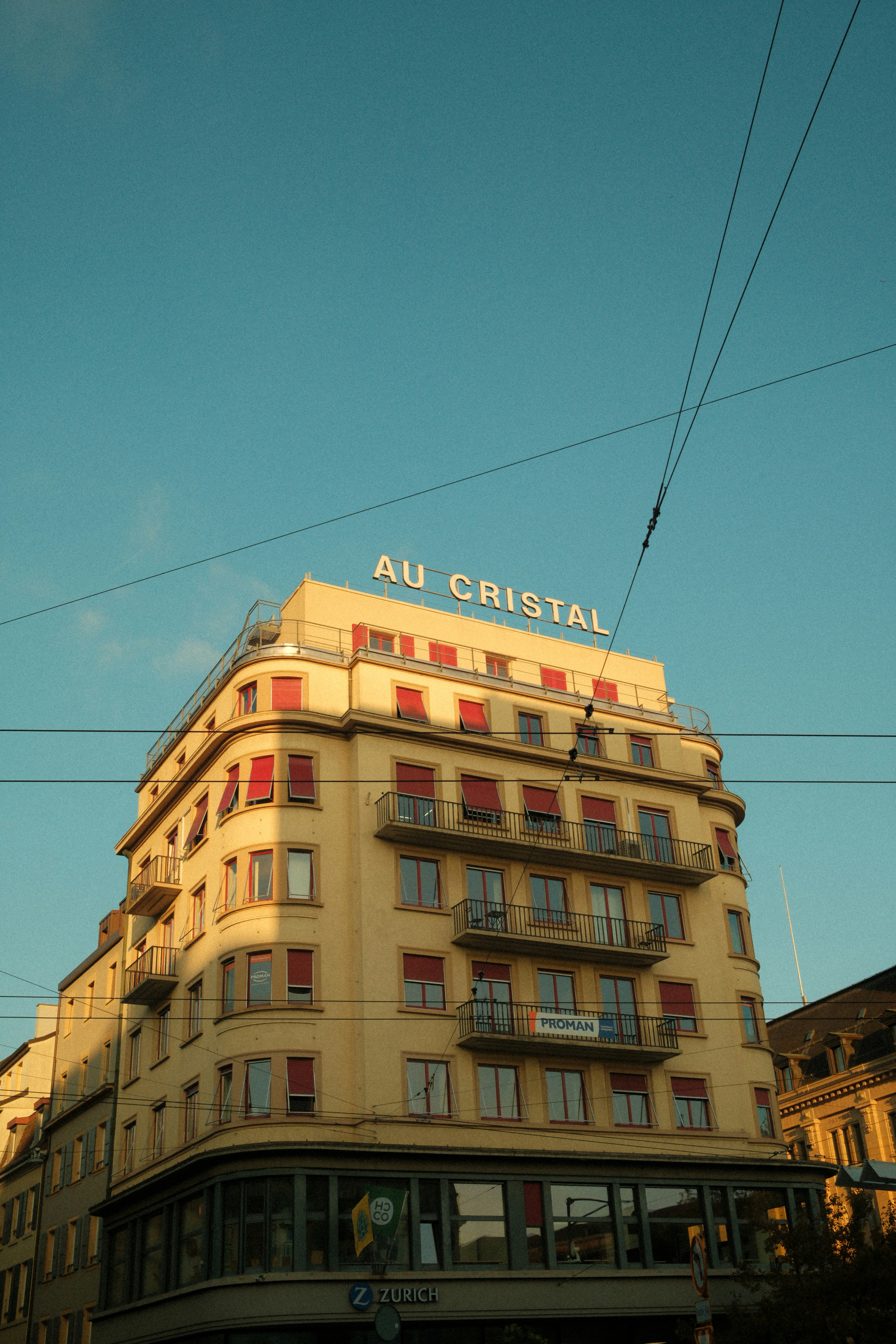 Sunlit Facade of Au Cristal Rising Above City Streets