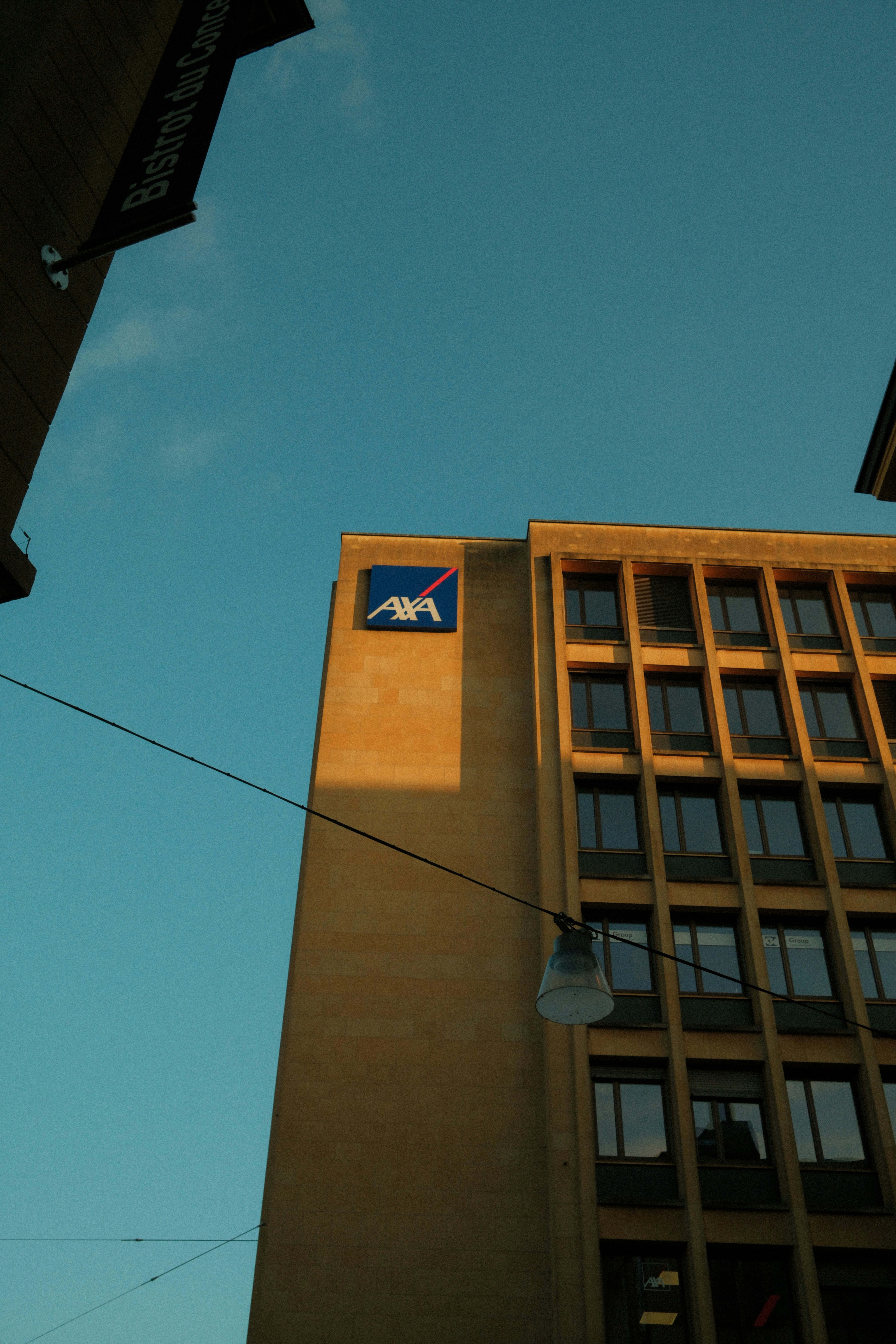 AXA Sign Anchored by a Concrete Tower Under a Clear Sky