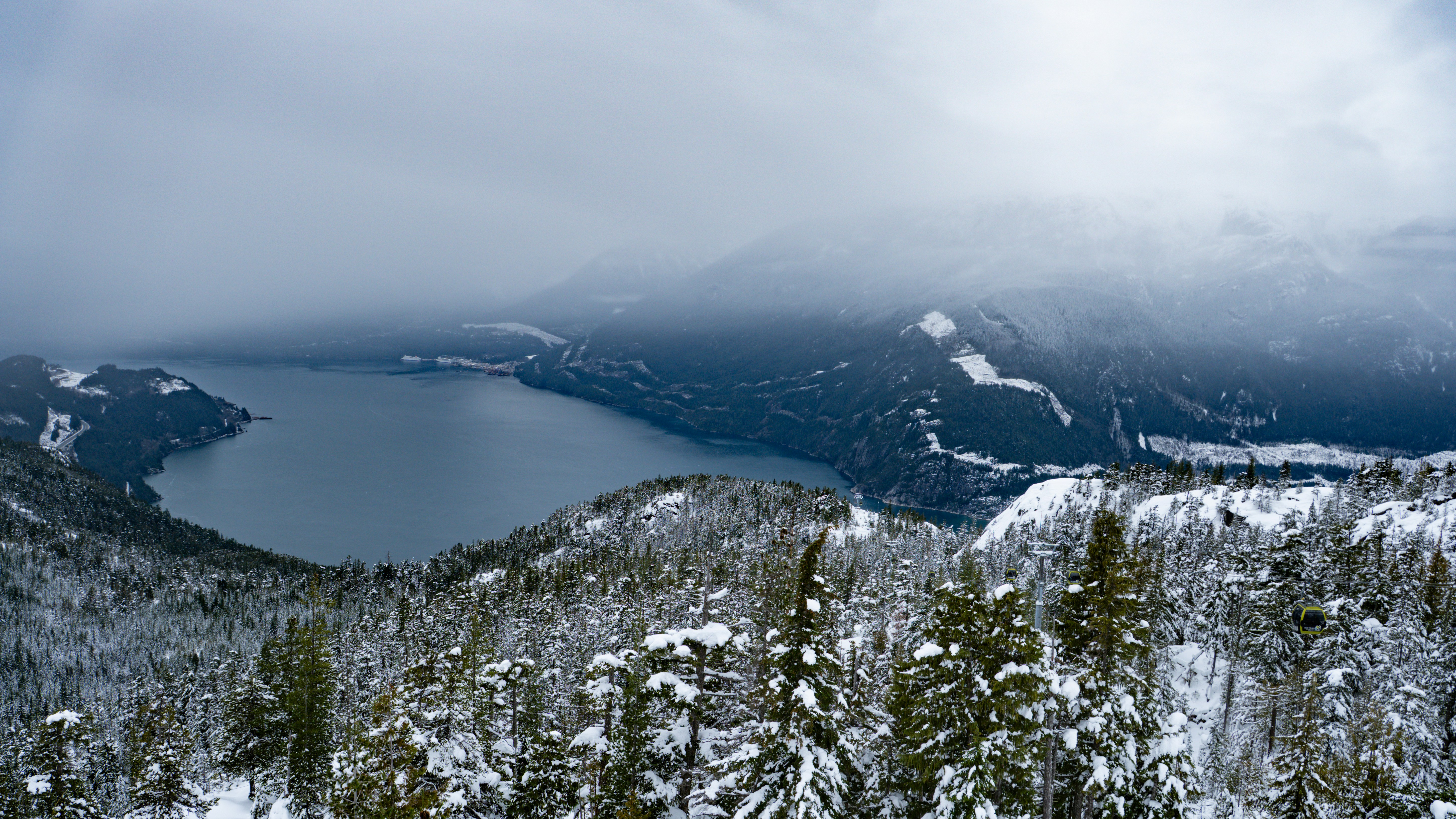 Mist over Cradled Peaks: A Snowbound Lake View