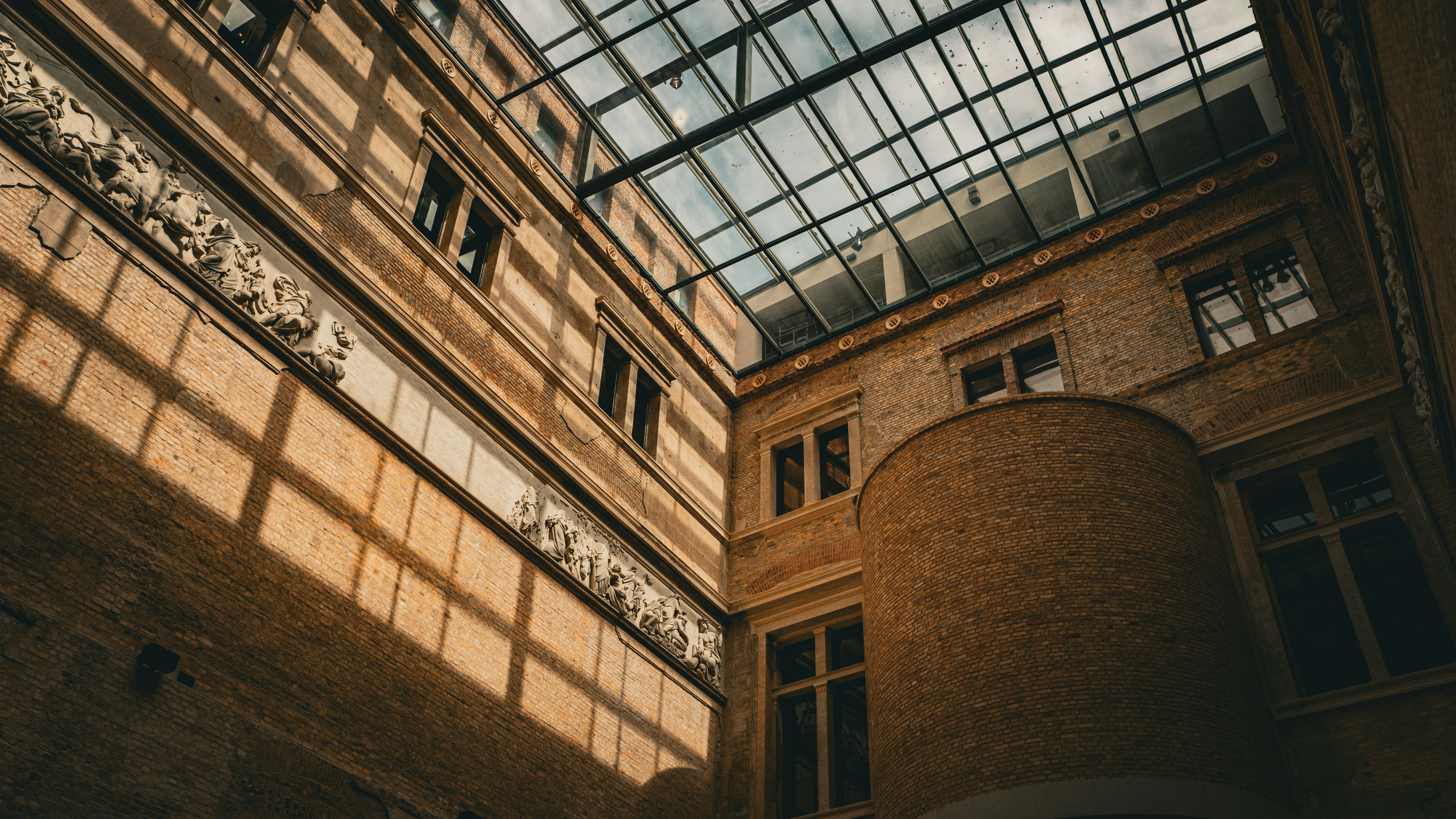 Sunlit Atrium: Brickwork and Glass Ceiling Casting Geometric Shadows