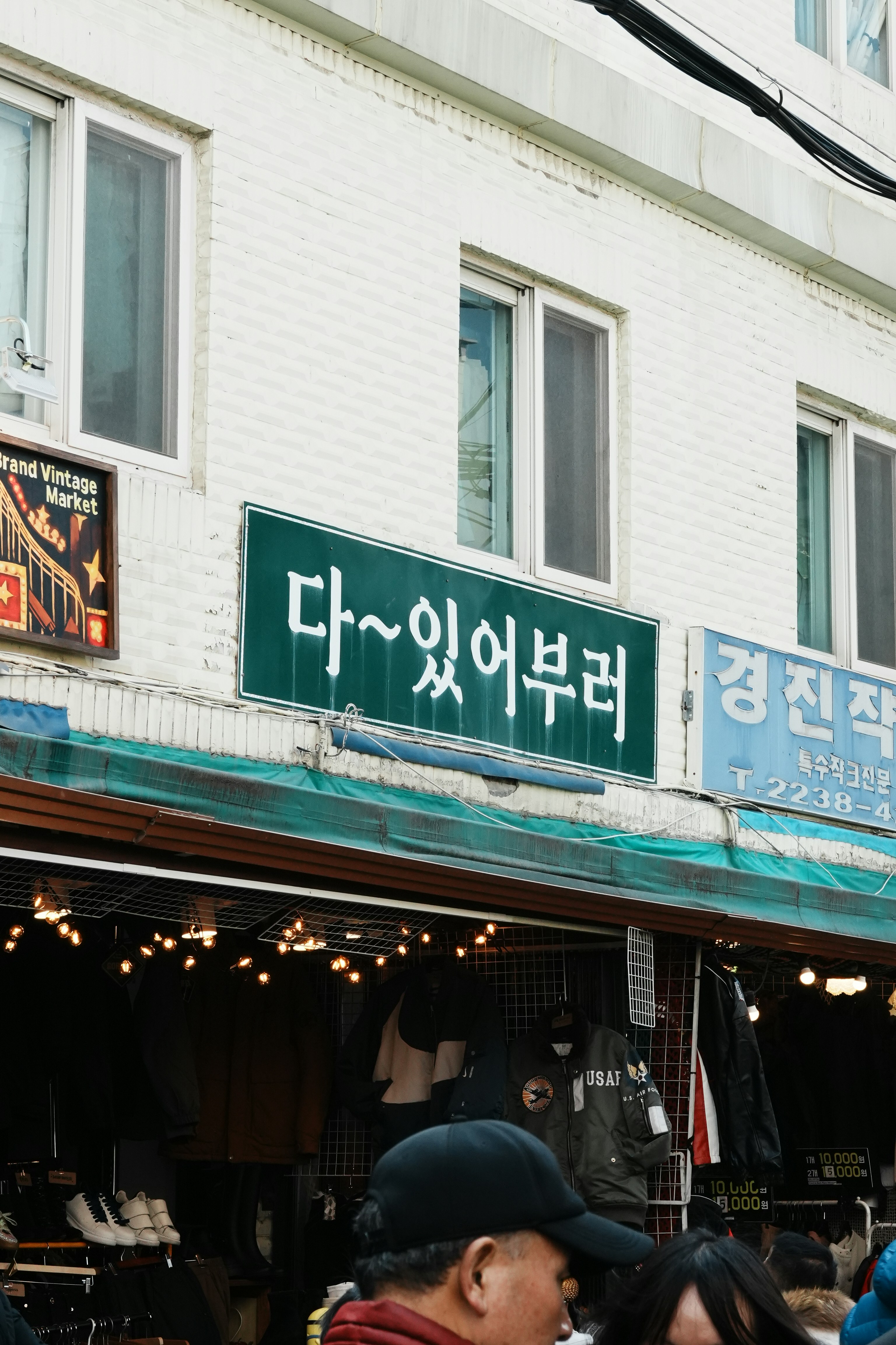 Streetwear Market Under Neon Signs: Korean Text and Hidden Details