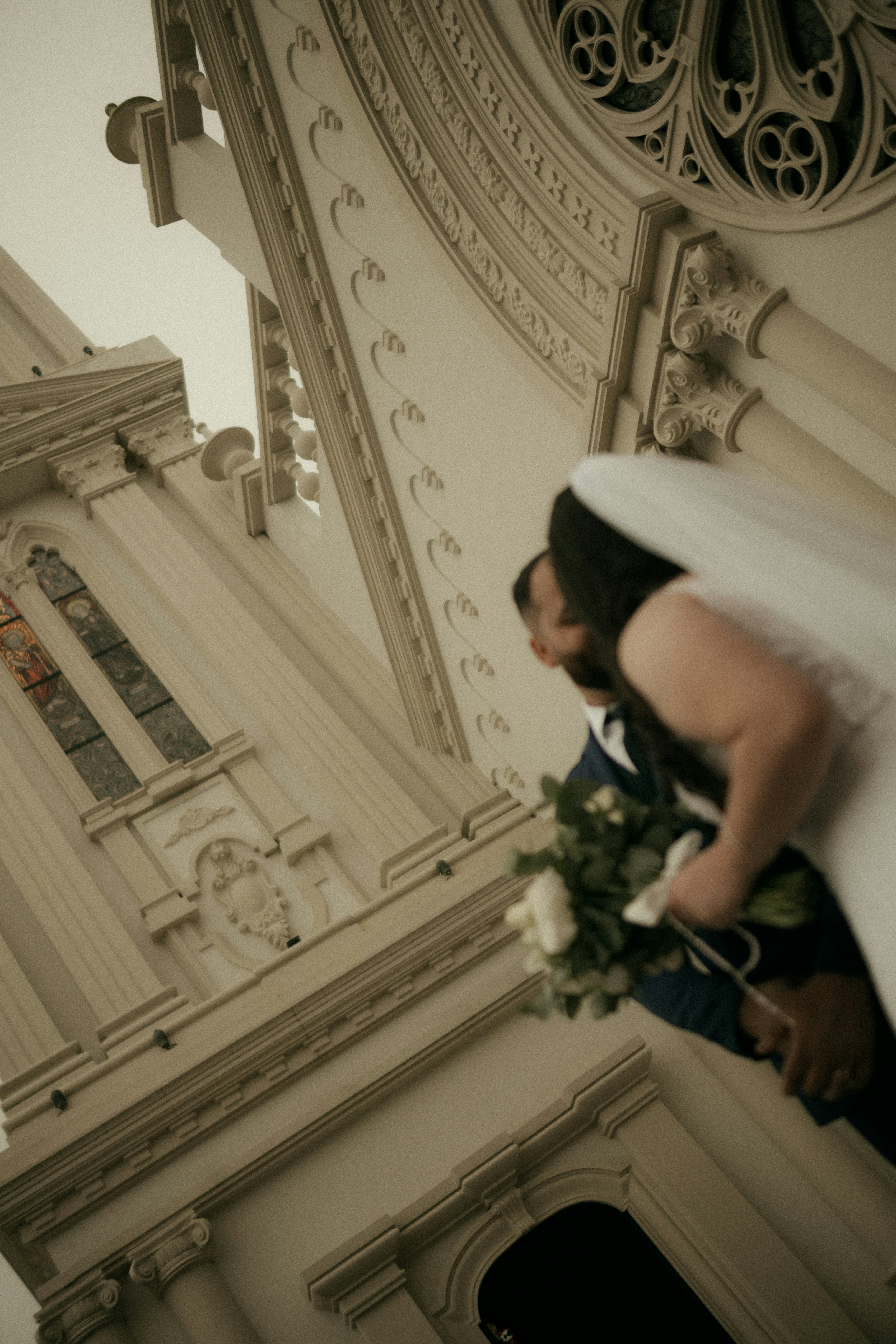 Tilted Union: A Bride and Groom Enveloped by Cathedral Grandeur