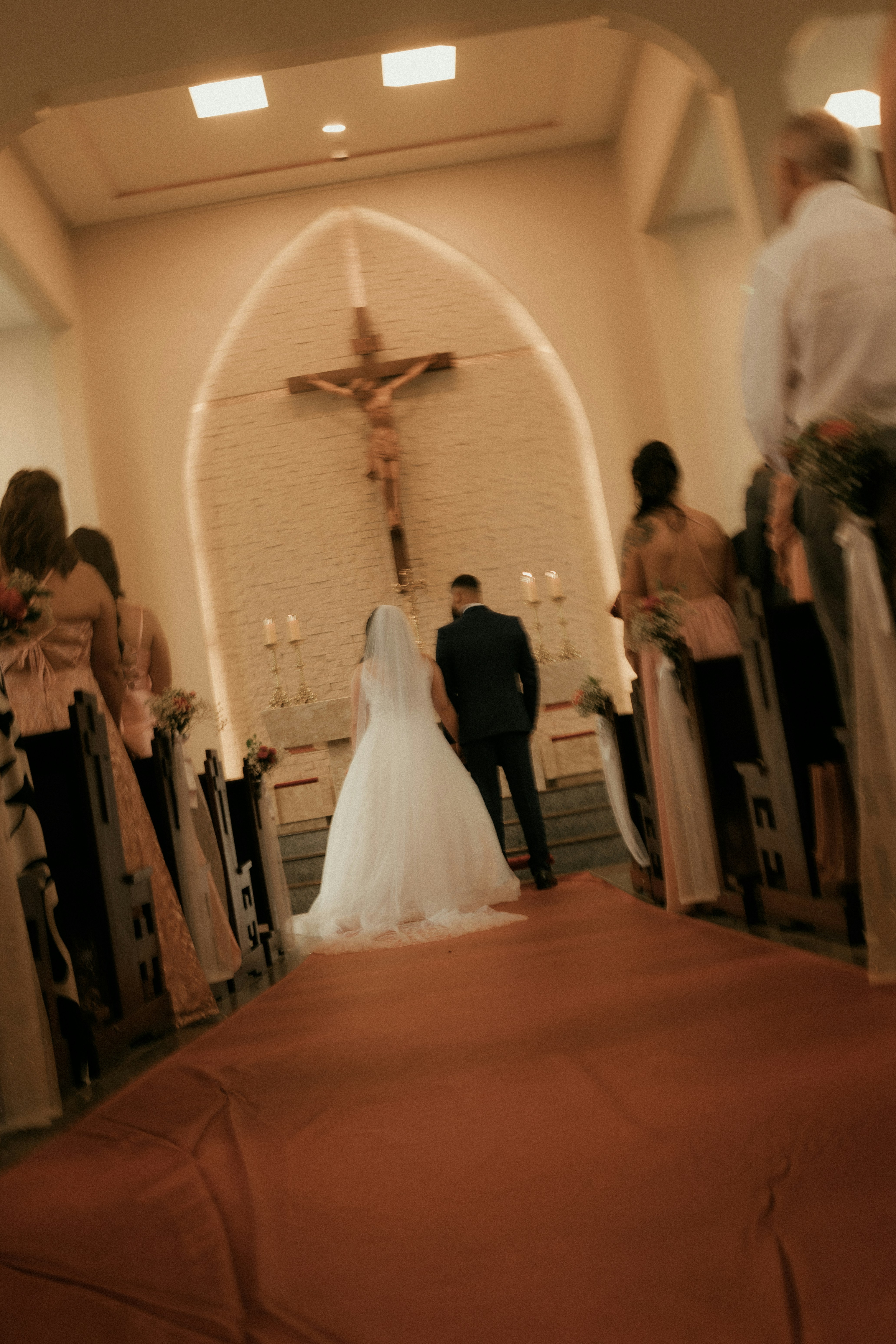 Bride and Groom Walked Toward the Altar Through a Warm, Blurred Chapel Aisle