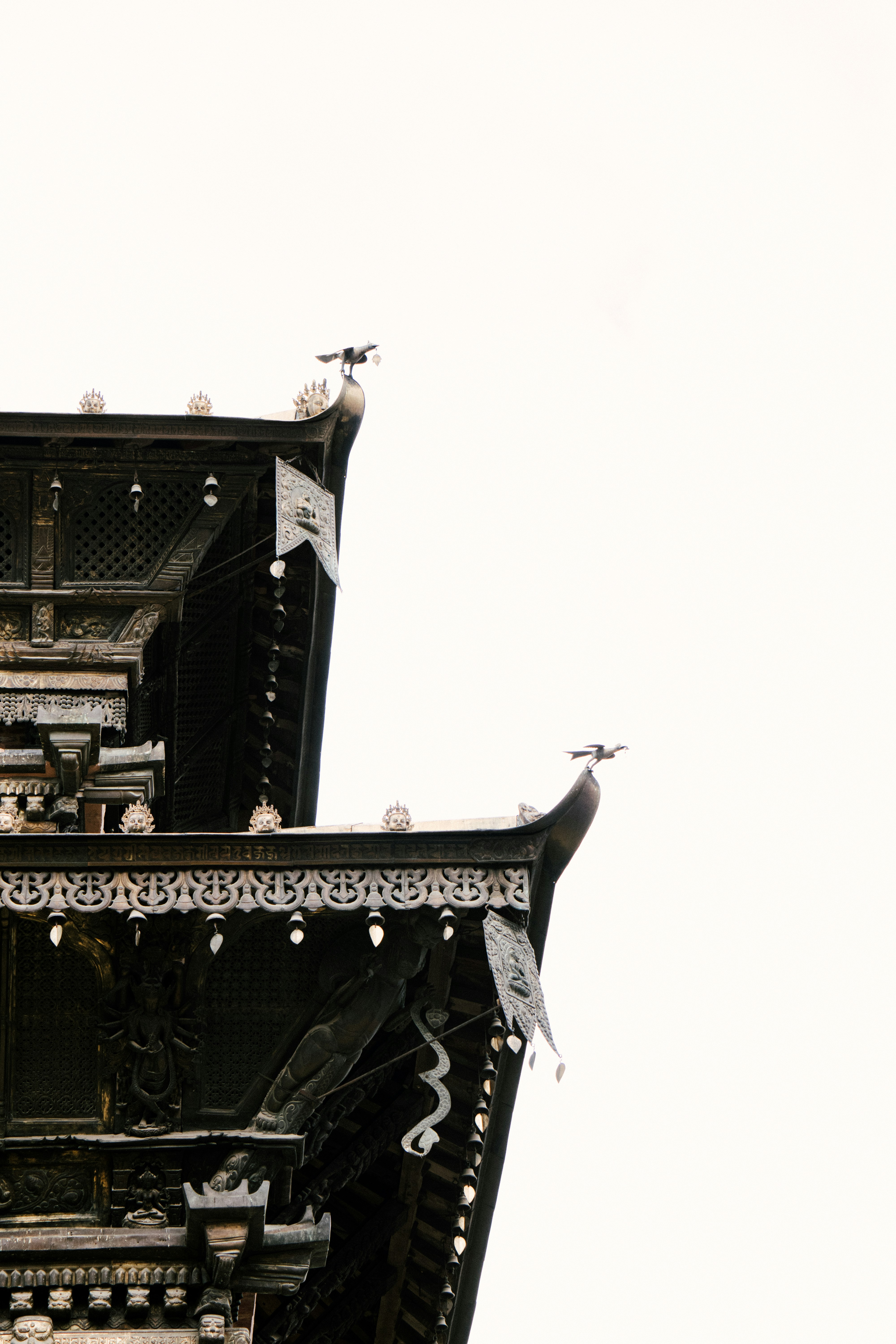 Architectural Eaves: Ornate Carvings Against Empty Sky