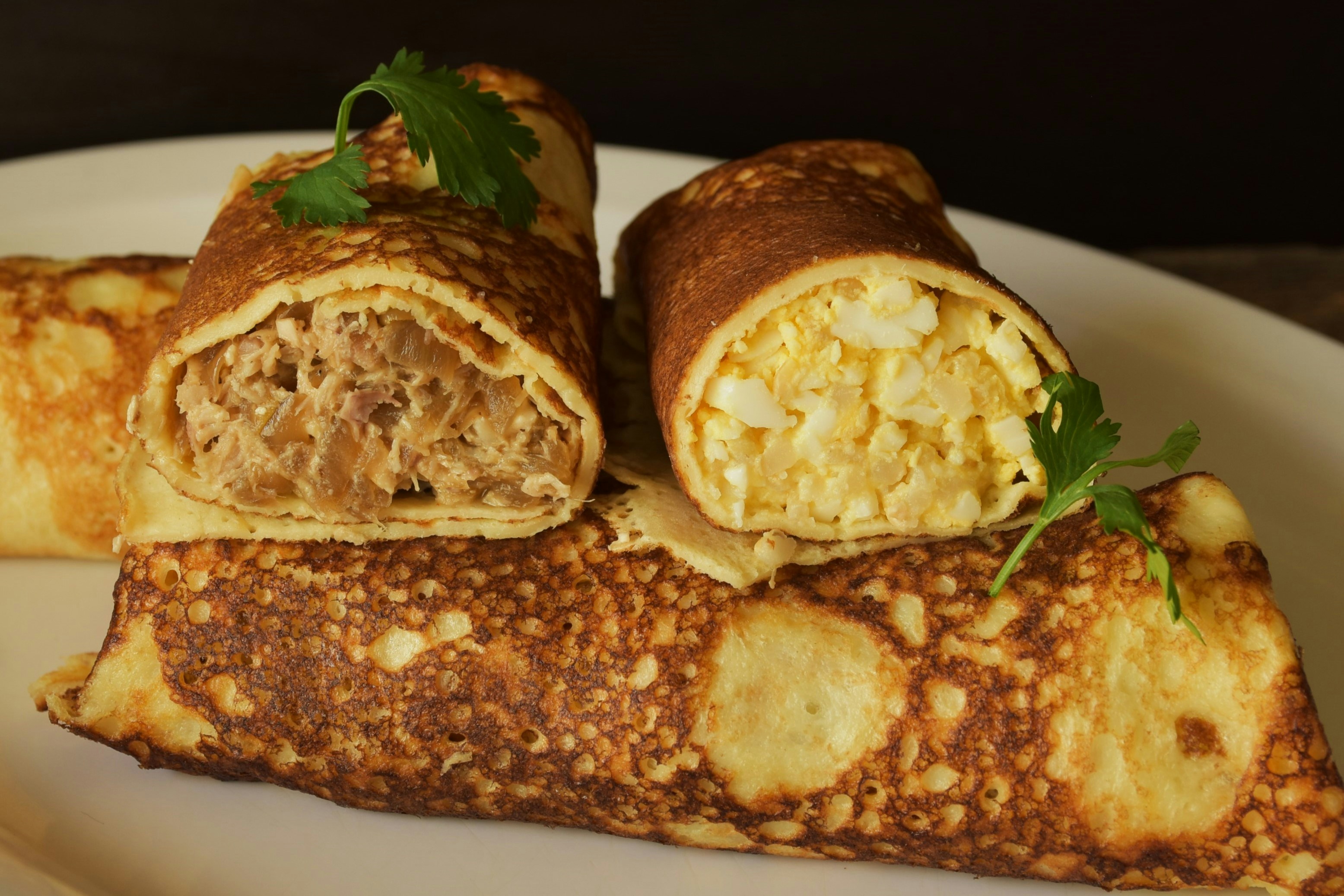 Golden-crusted pastry rolls with savory fillings on a plate
