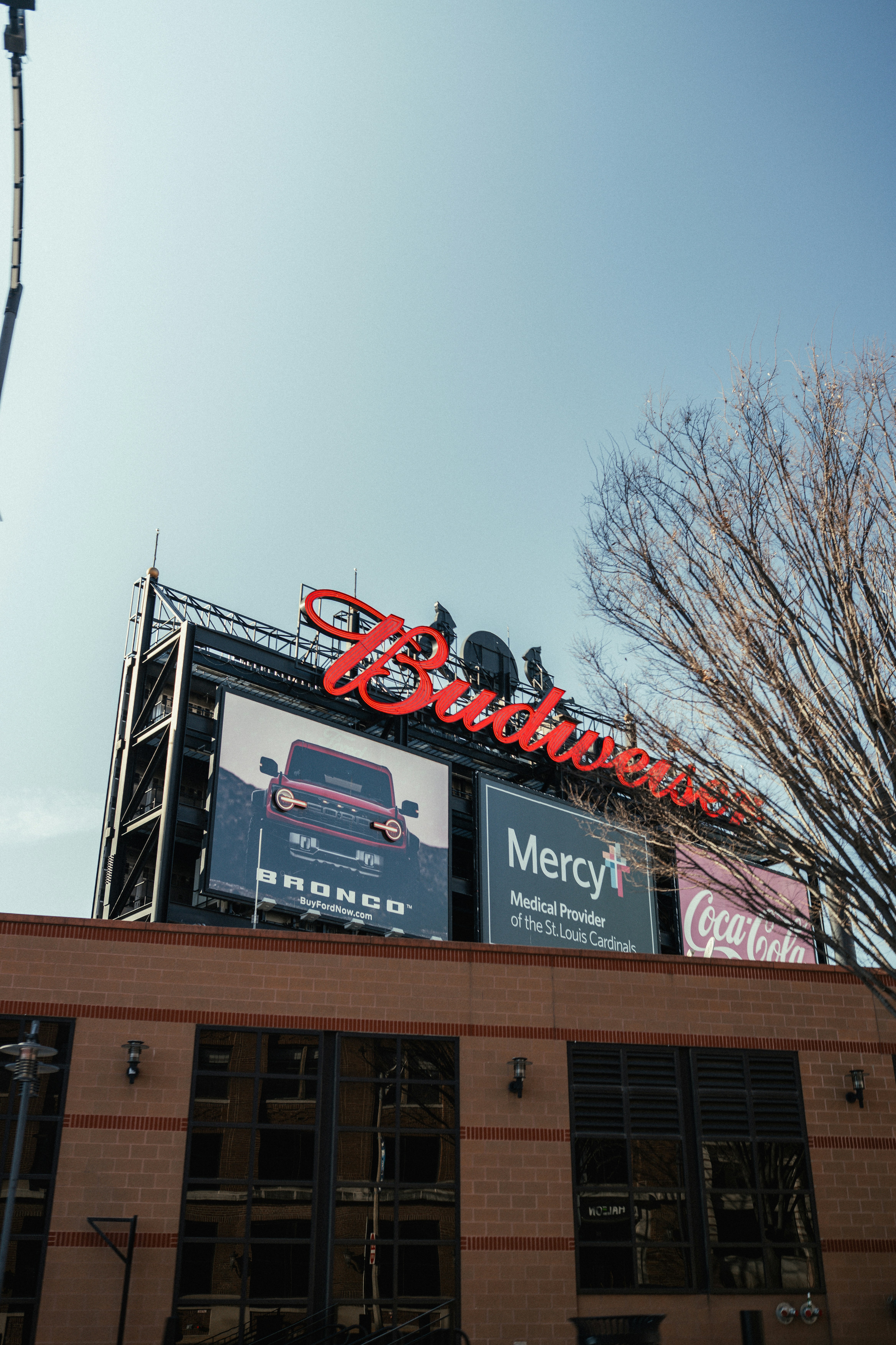Retro Neon on a Bright Day: Budweiser Sign Over the Car Park