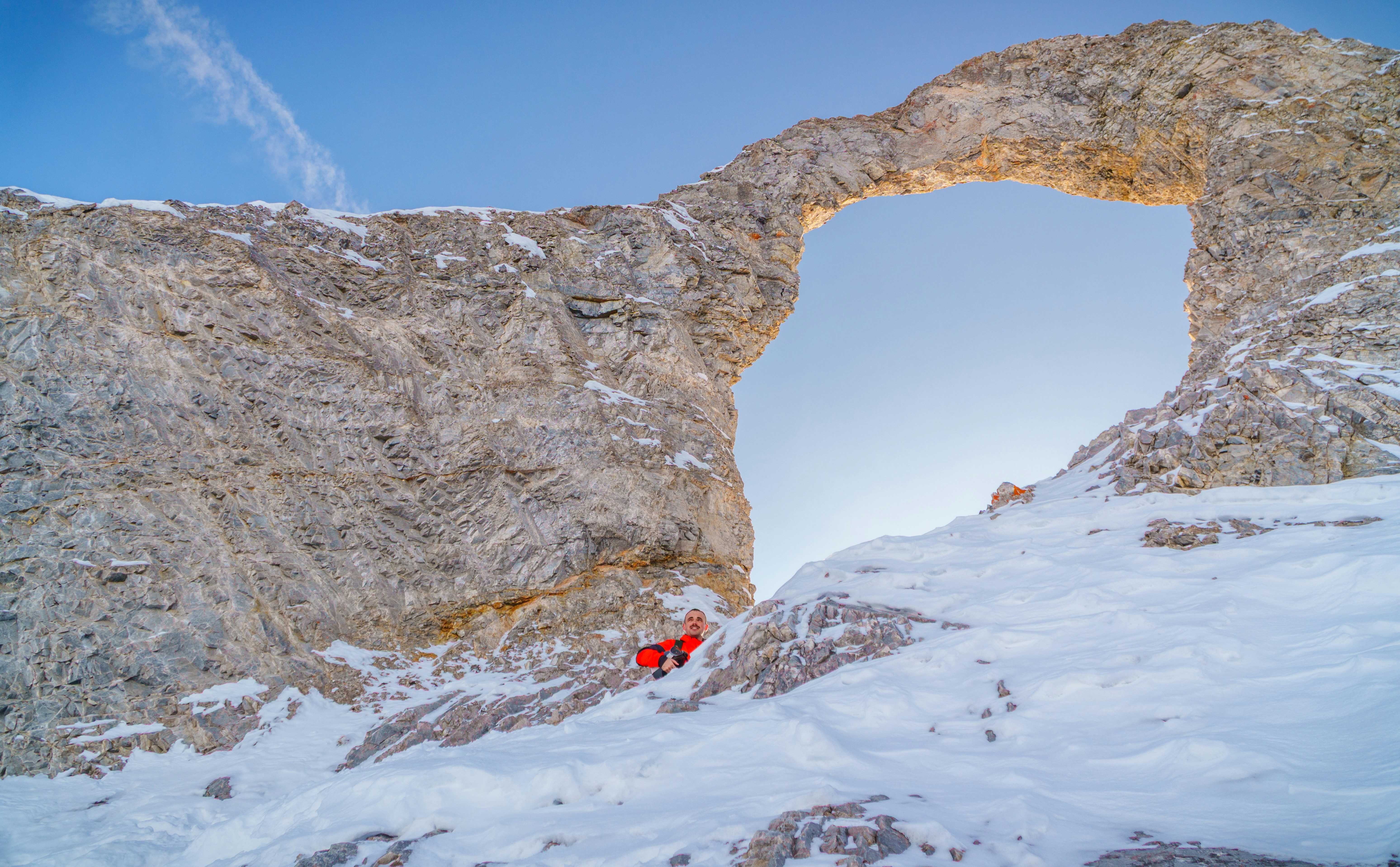 Archway of Snow: Climber Silhouette Beneath a Mountain Portal