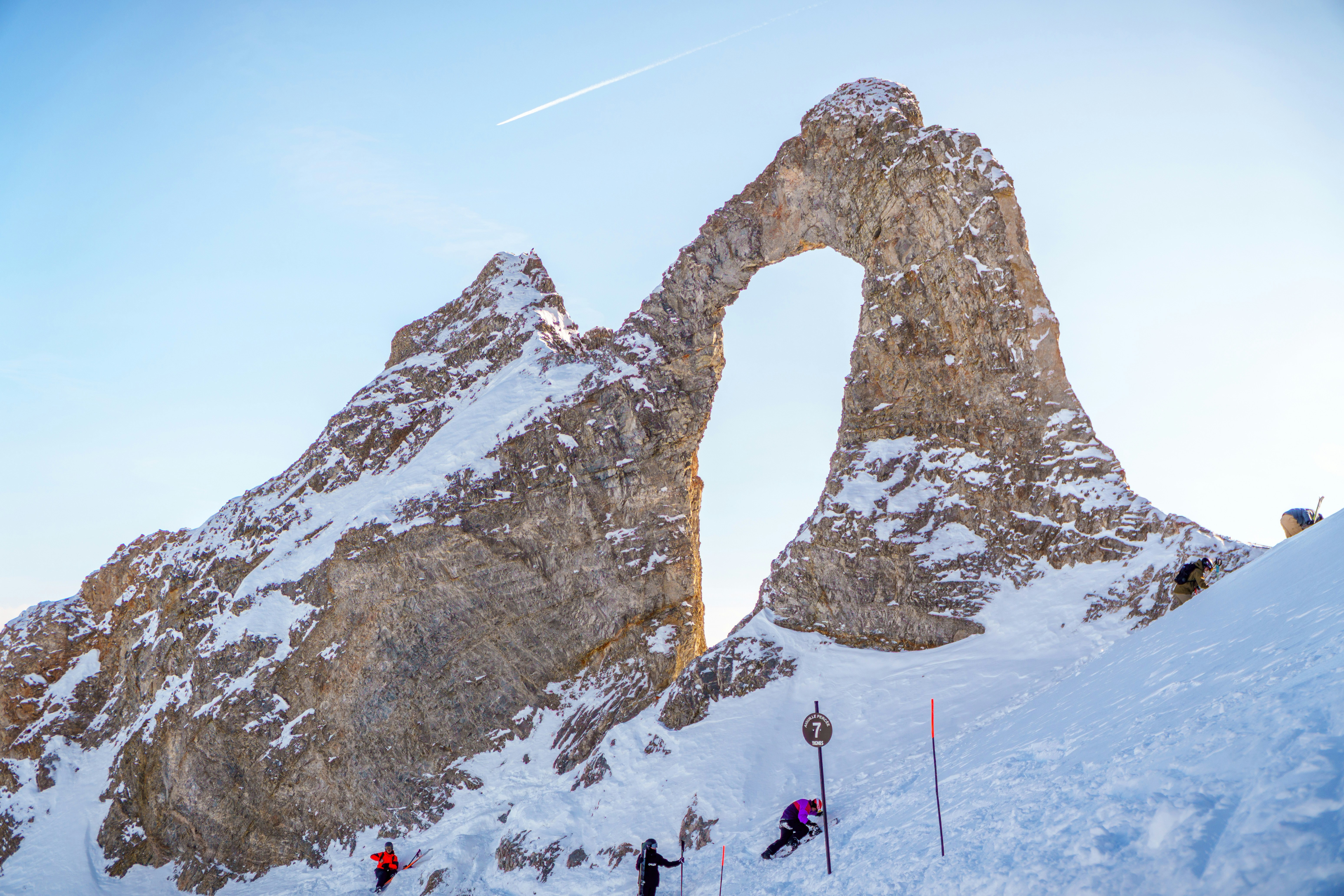 Arch of Ice: Climbers Beneath a Sky-etched Summit