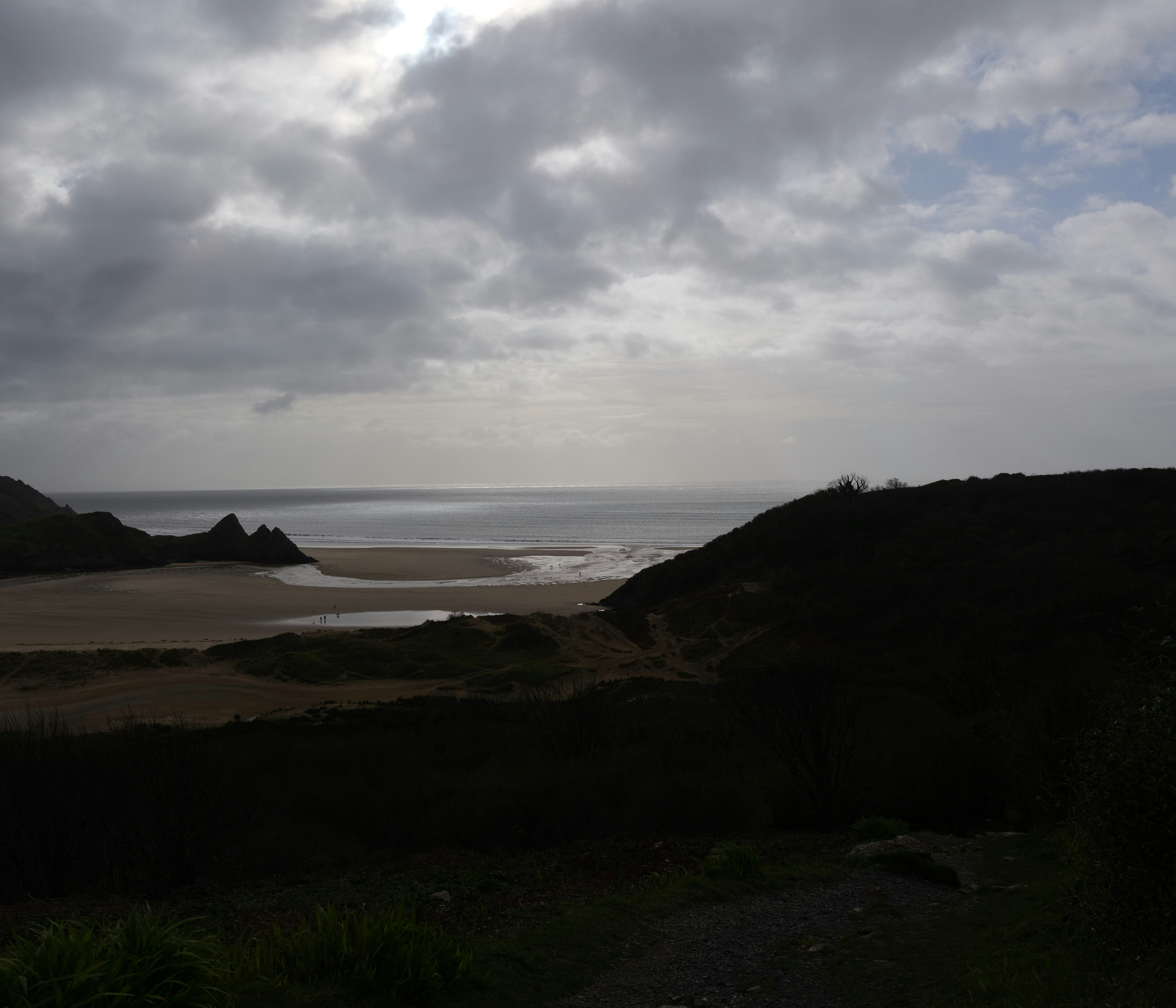 Quiet Sea Gap: A Dusk-Hushed Beach Under Cloudy Skies