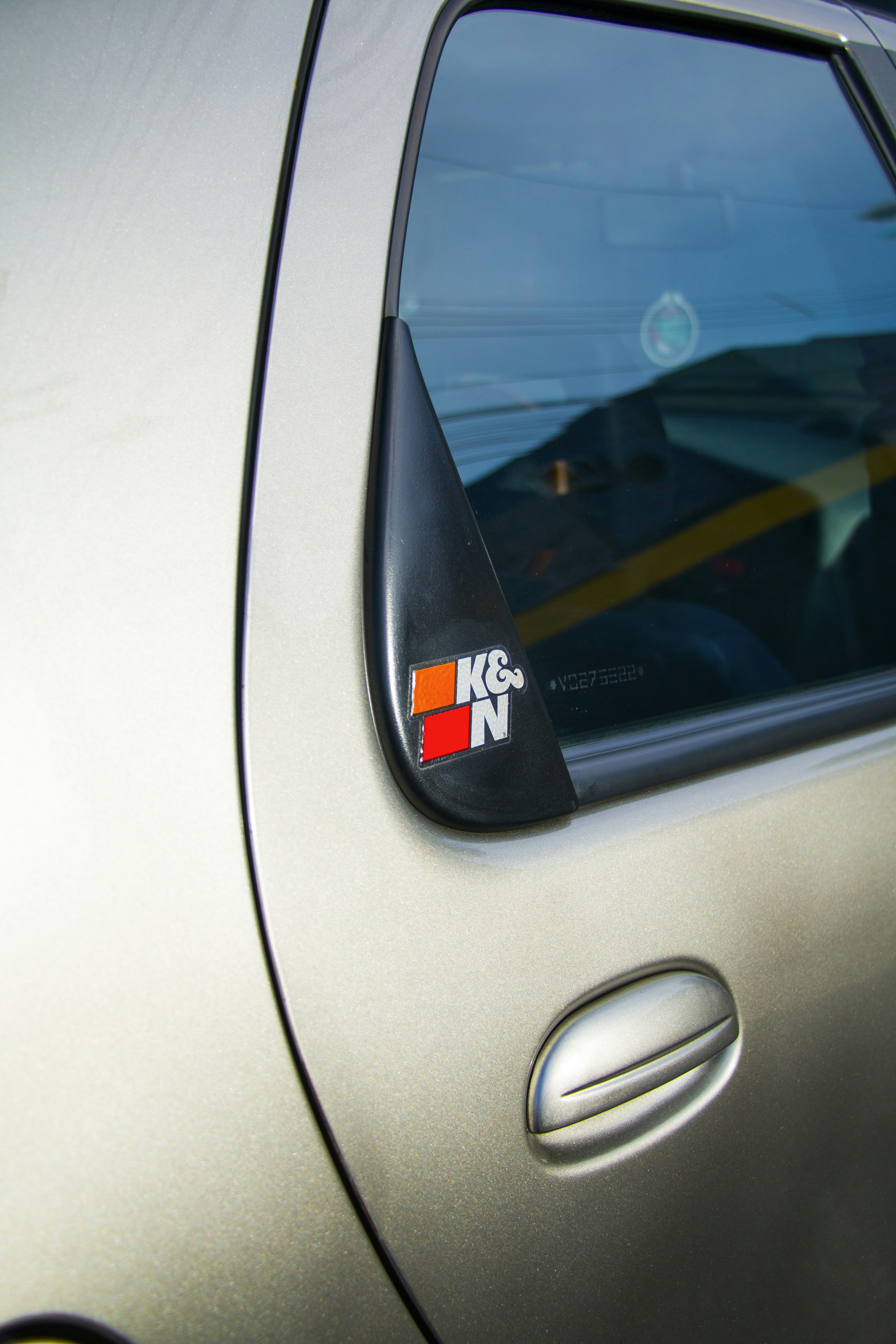 Stickered window: a framed close-up of a car door window and K&N badge
