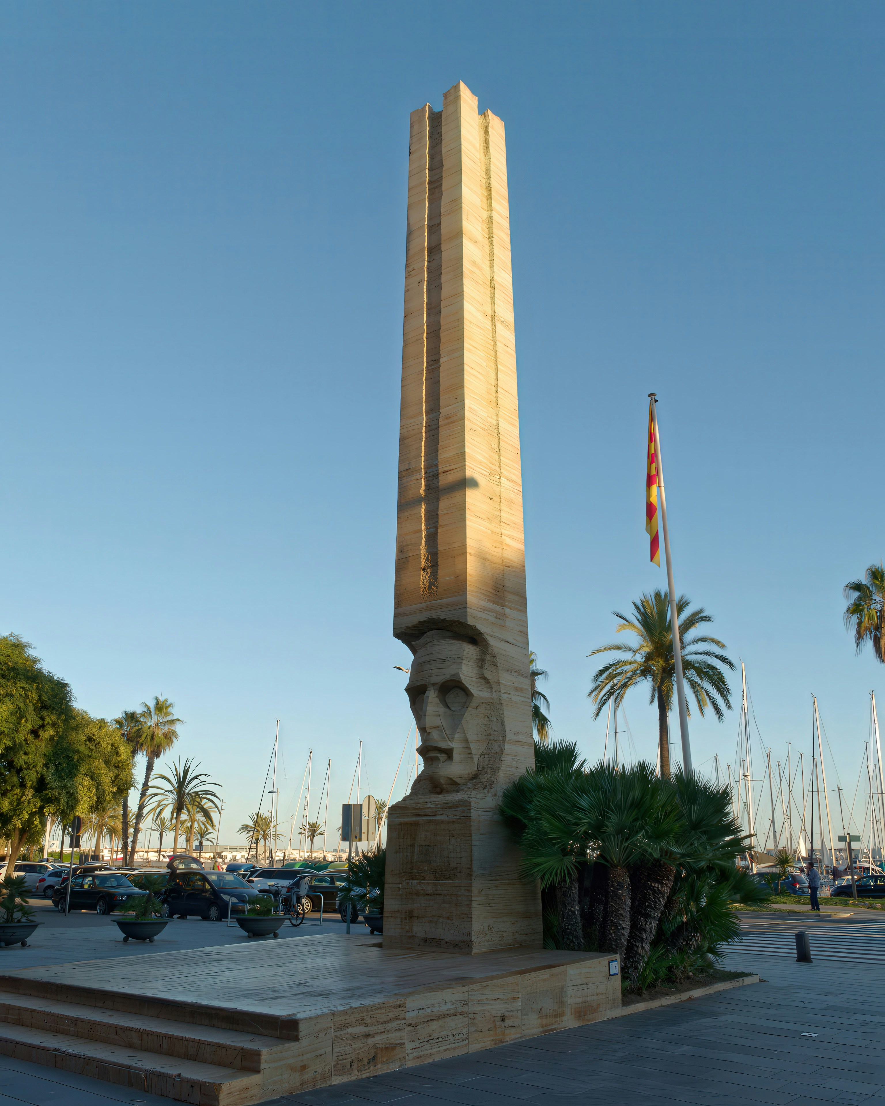 Tall monument with a carved face and palm trees