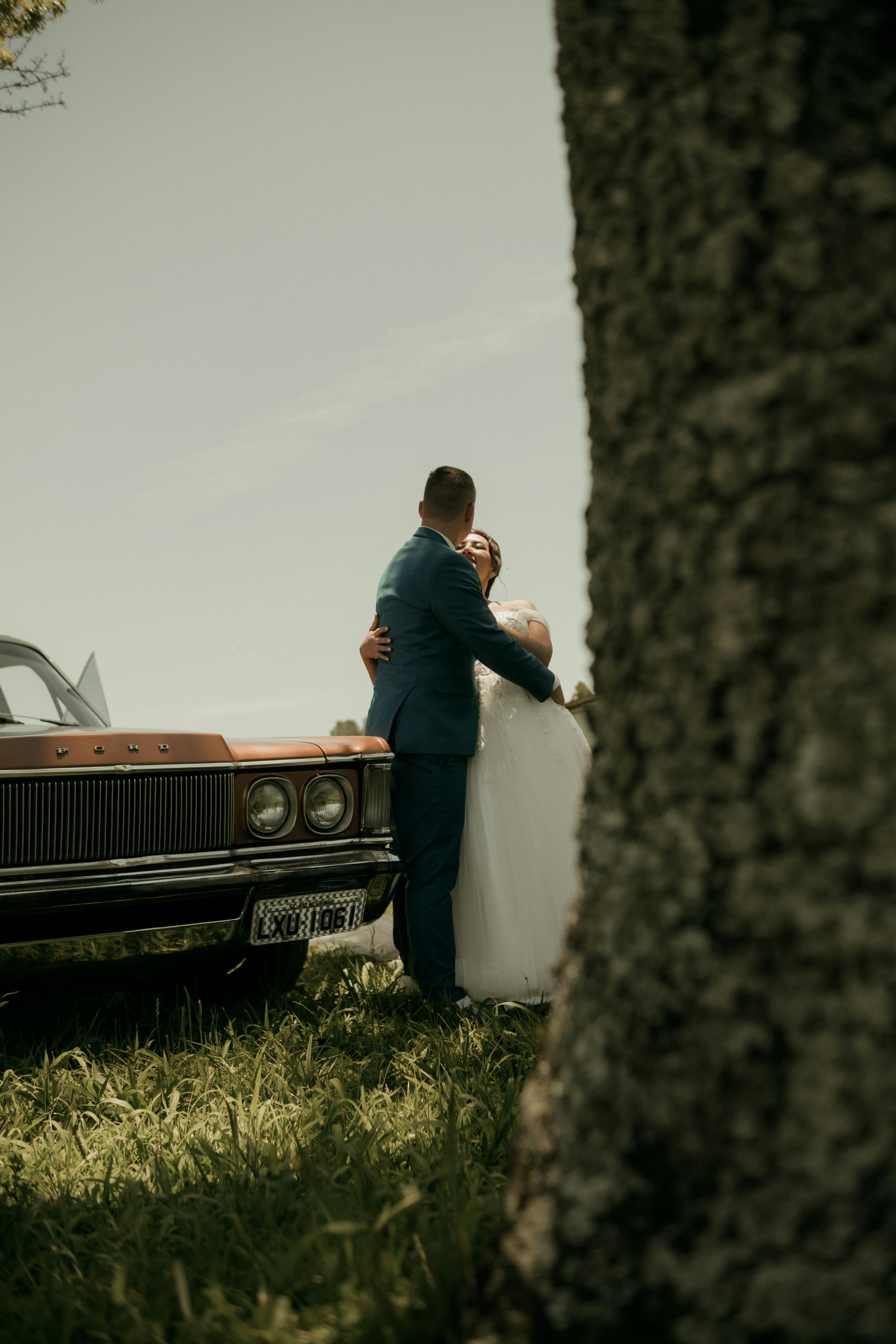 Embrace by the Old Sedan: A Quiet Vow Beside Timeworn Chrome