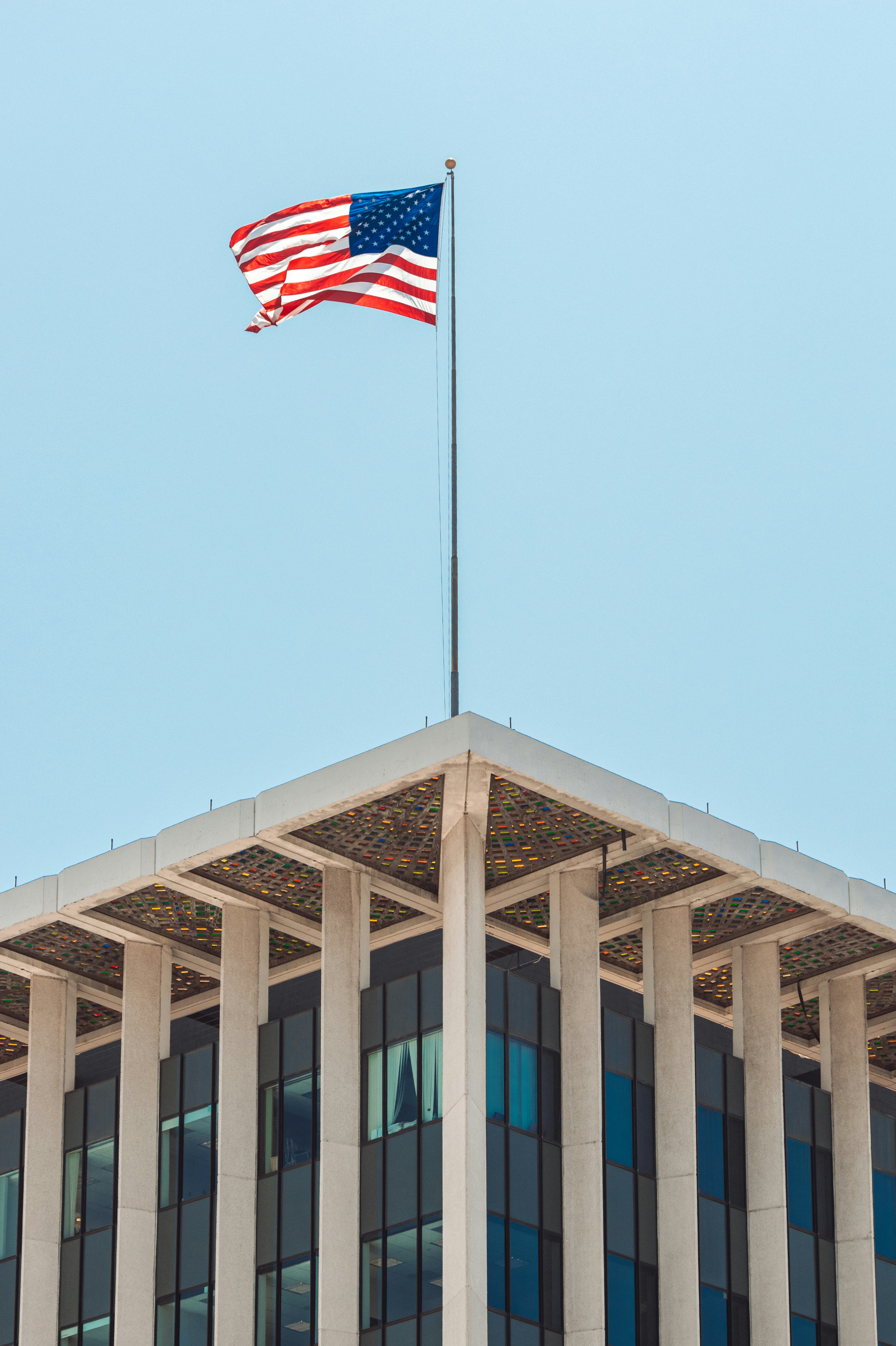 Flag atop a sunlit modern capstone