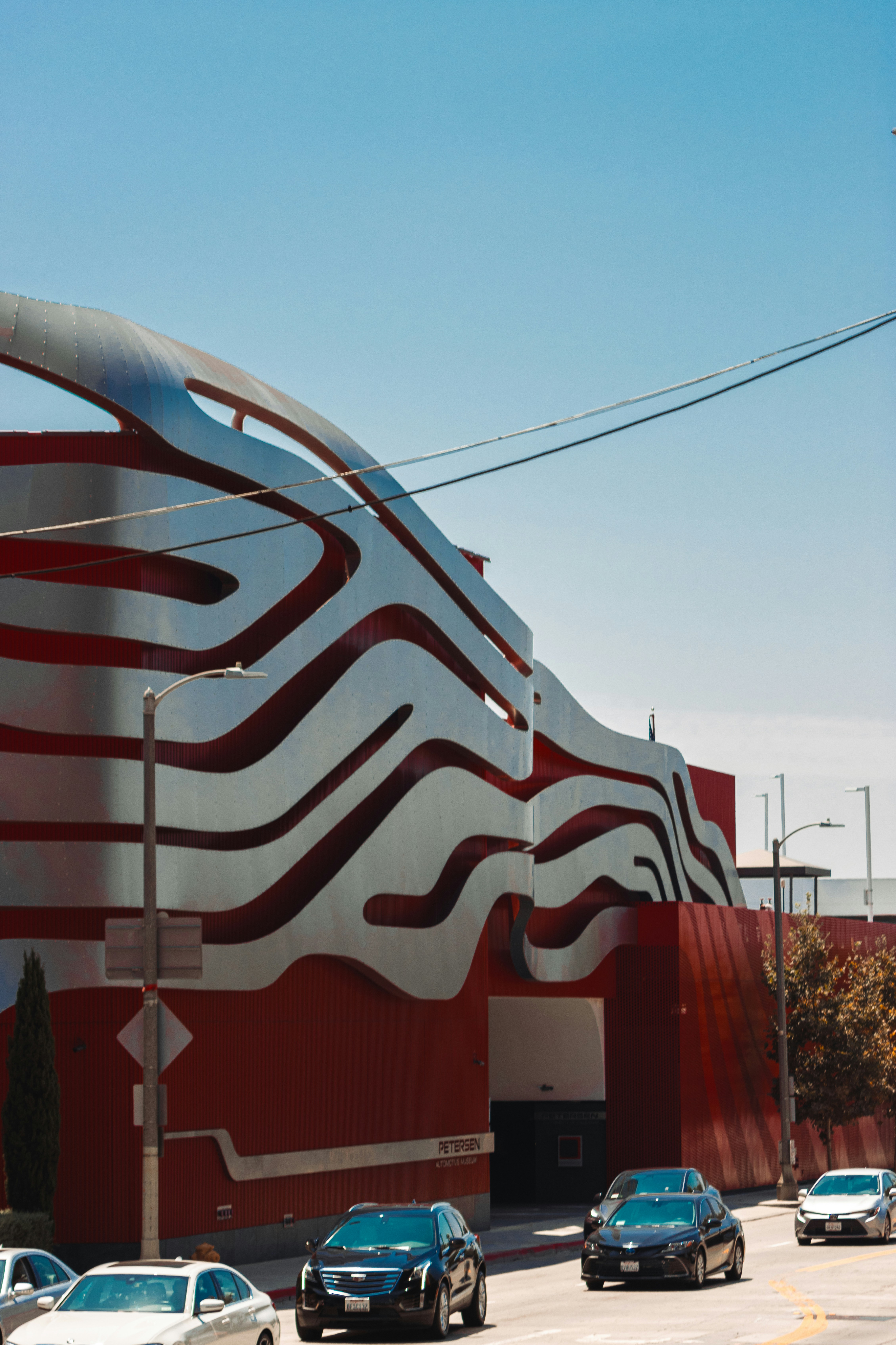 Red Wave Architecture: Streetside Facade with Fluid White and Crimson Lines